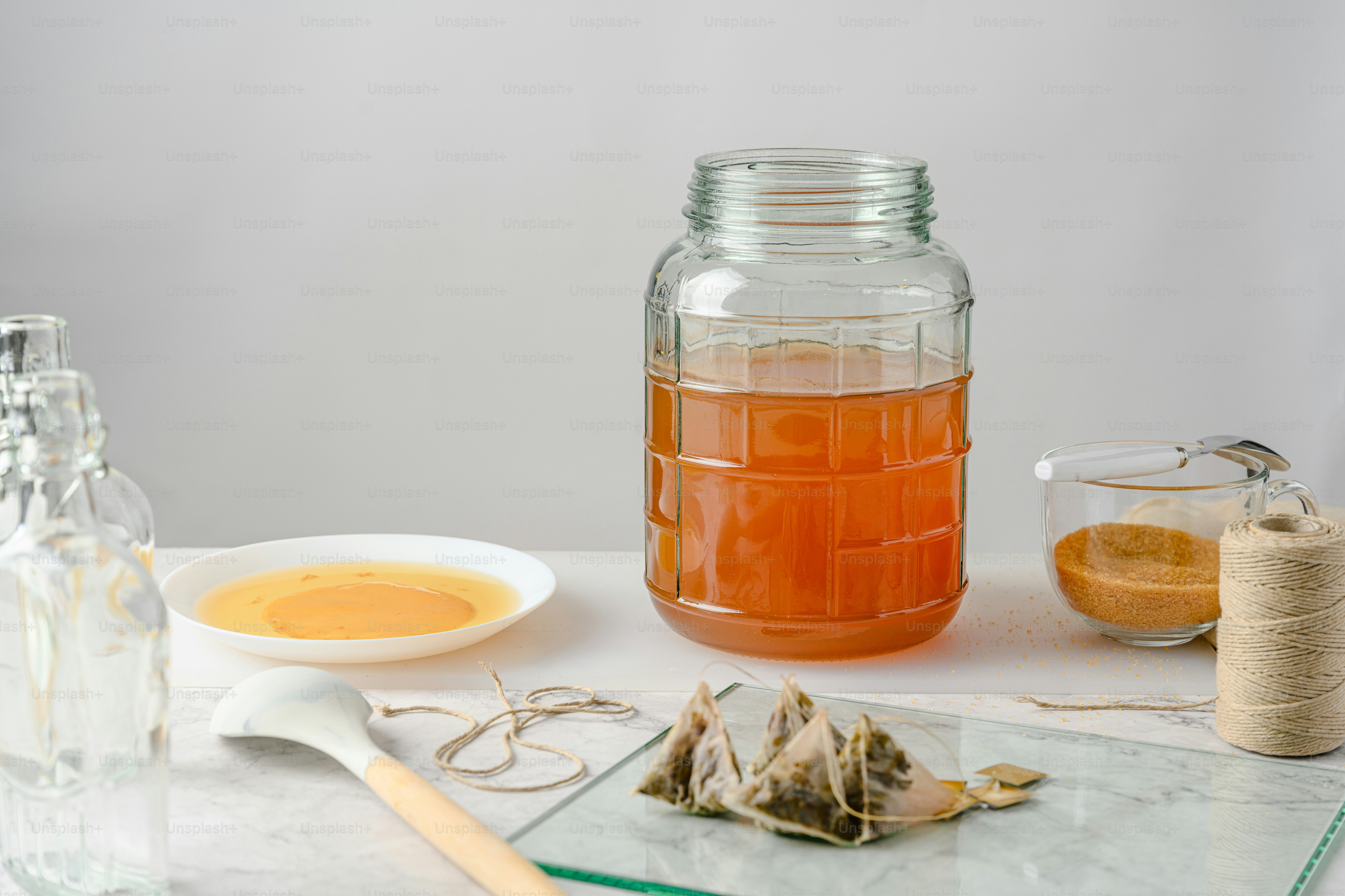 A jar of liquid sitting on top of a table photo – Kombucha Image on ...