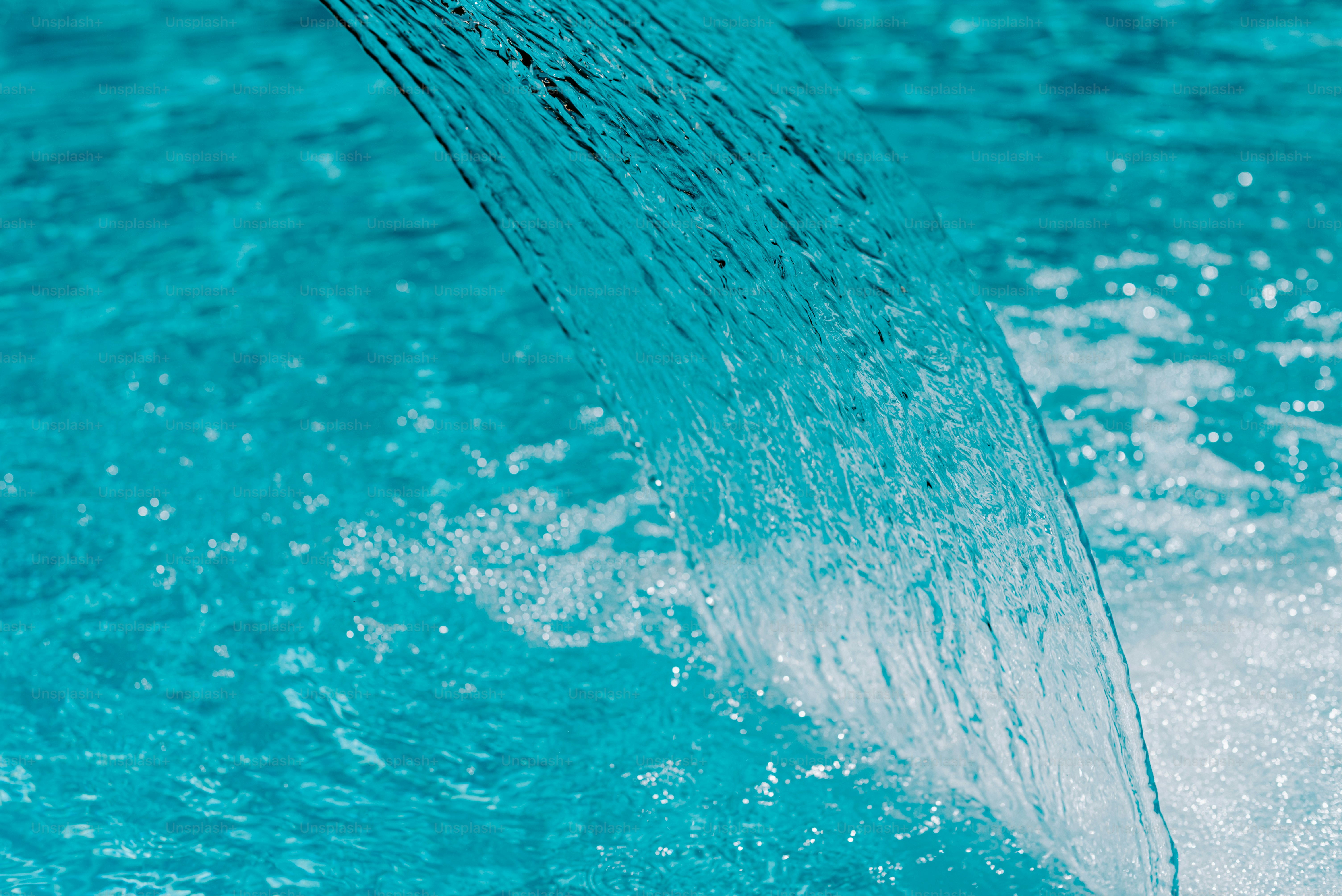 A water spewing out of a blue swimming pool photo – Wallpaper Image on ...