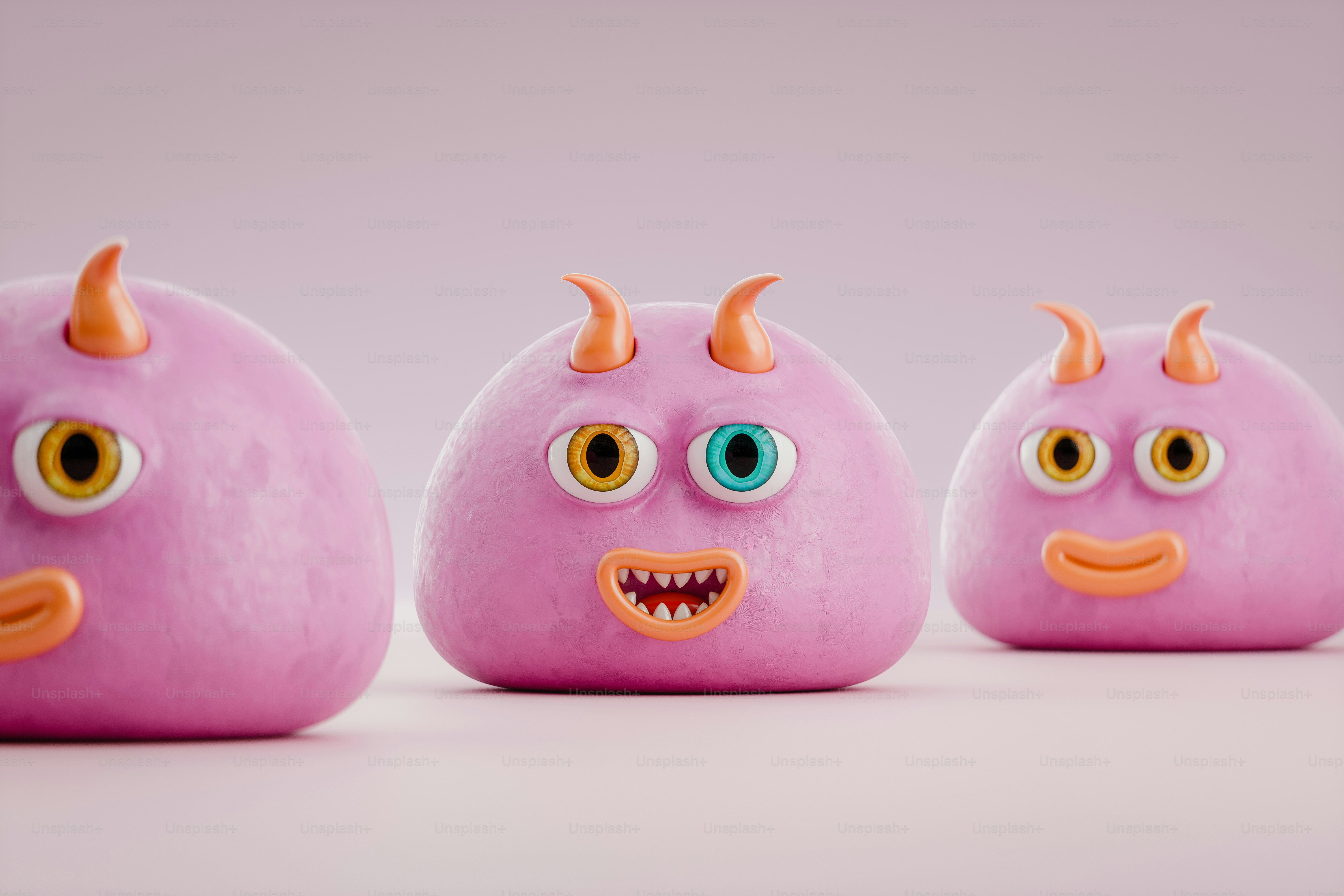 A group of three pink balls with orange horns and eyes photo – Horns ...