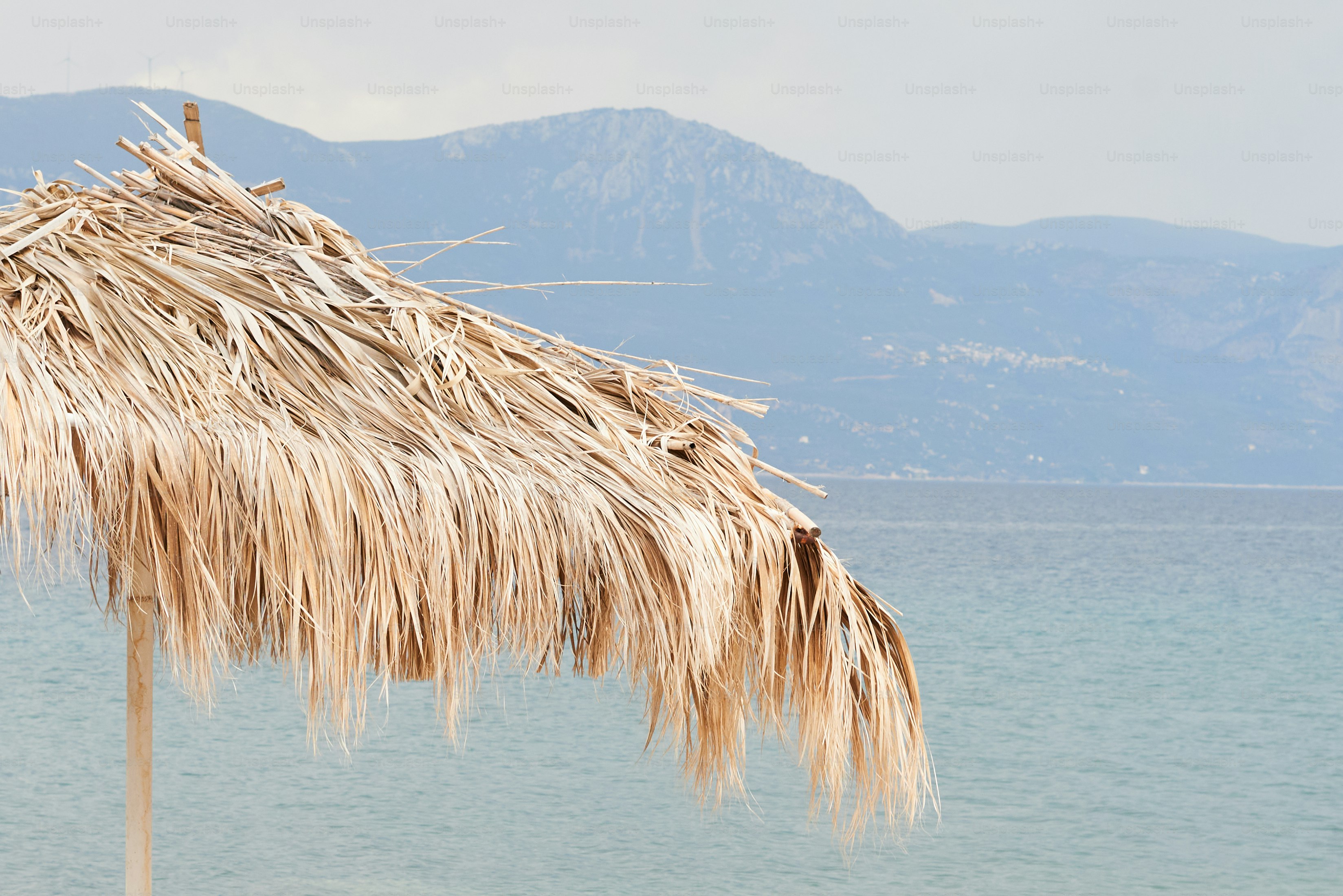 A straw umbrella sitting on top of a sandy beach photo – Textures Image ...