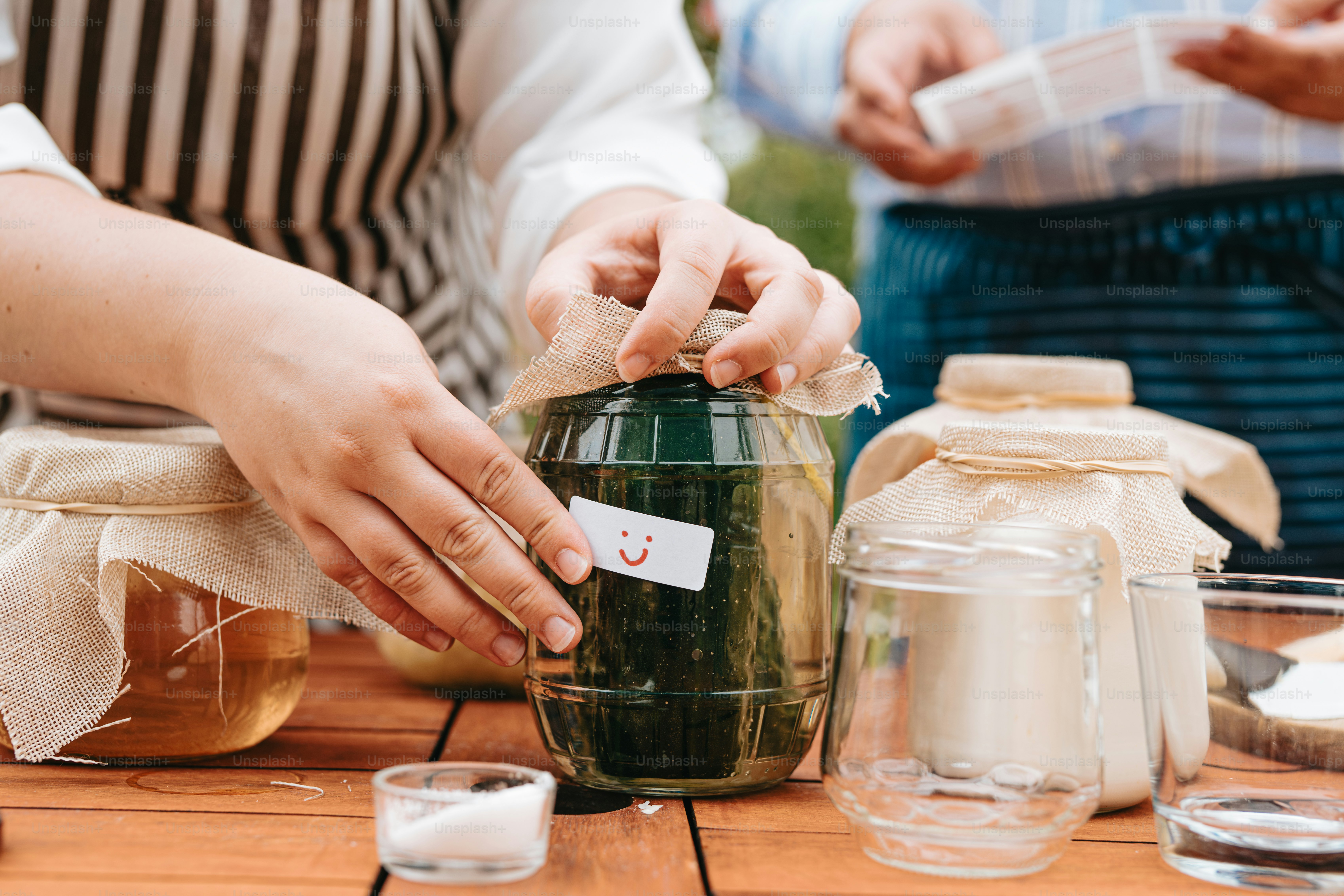 A couple of people standing around a jar filled with liquid photo ...