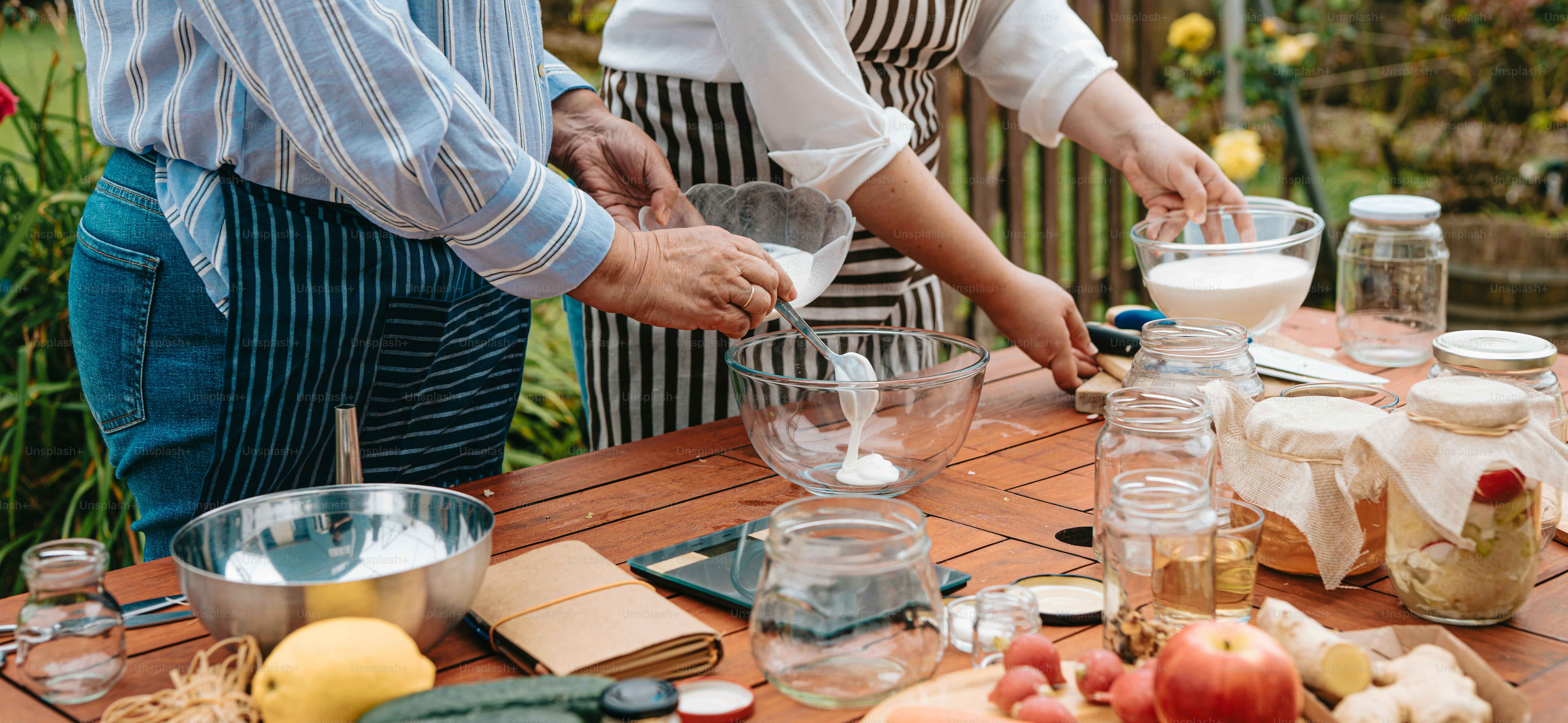 A man and a woman preparing food on a table photo – Learning Image on ...