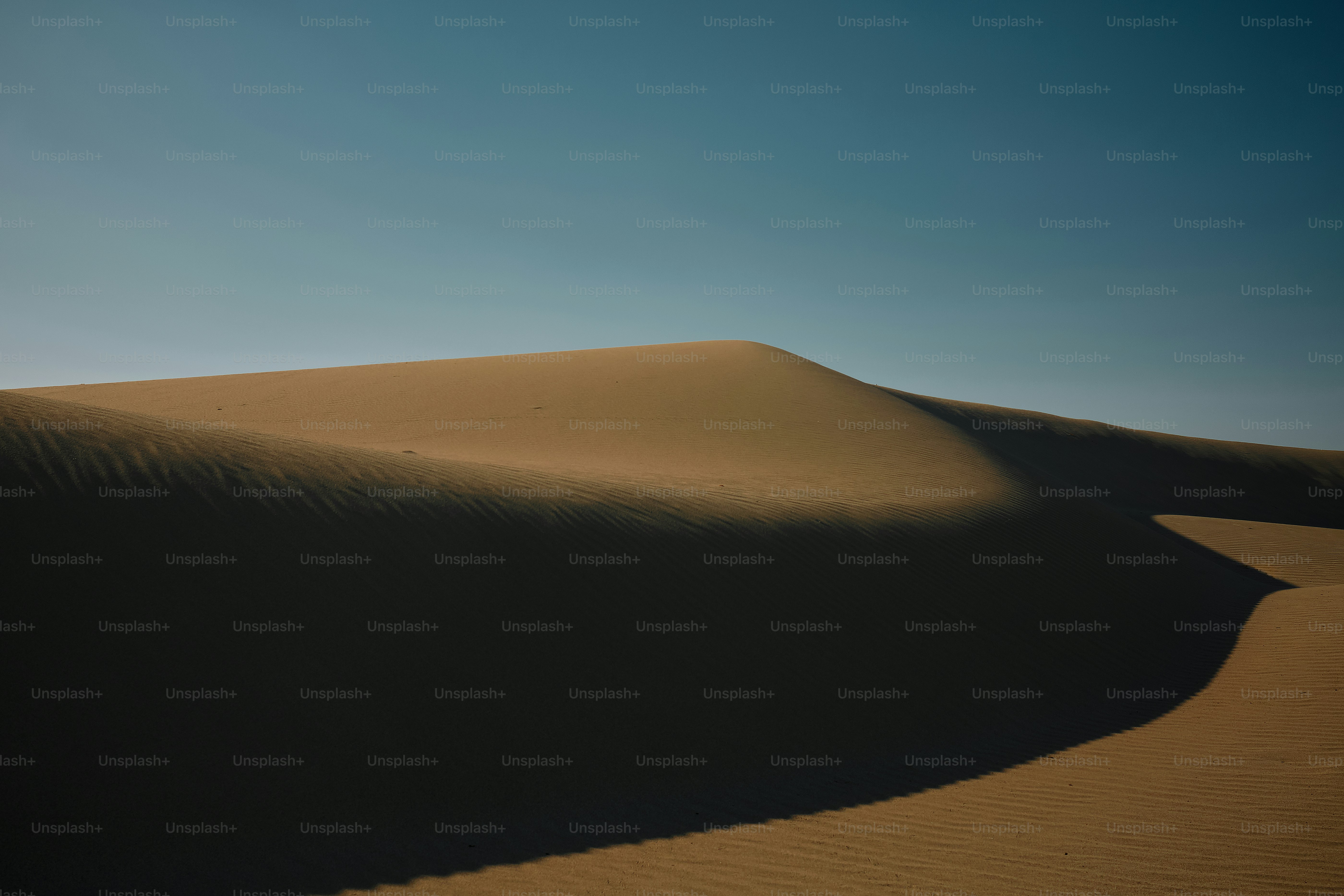 A large sand dune in the middle of a desert photo – Wallpaper Image on ...