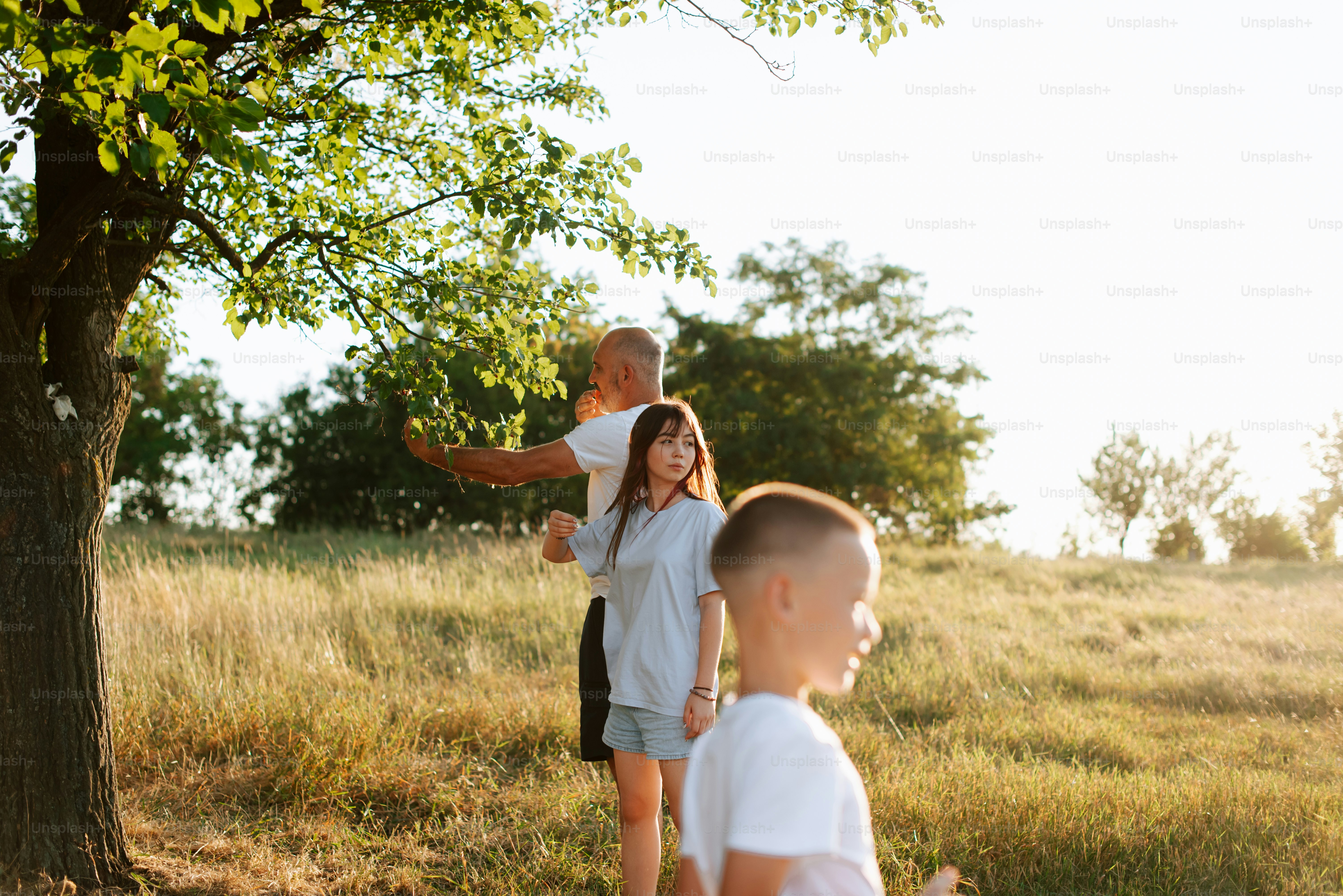 A couple of kids standing next to a tree photo – Family Image on Unsplash