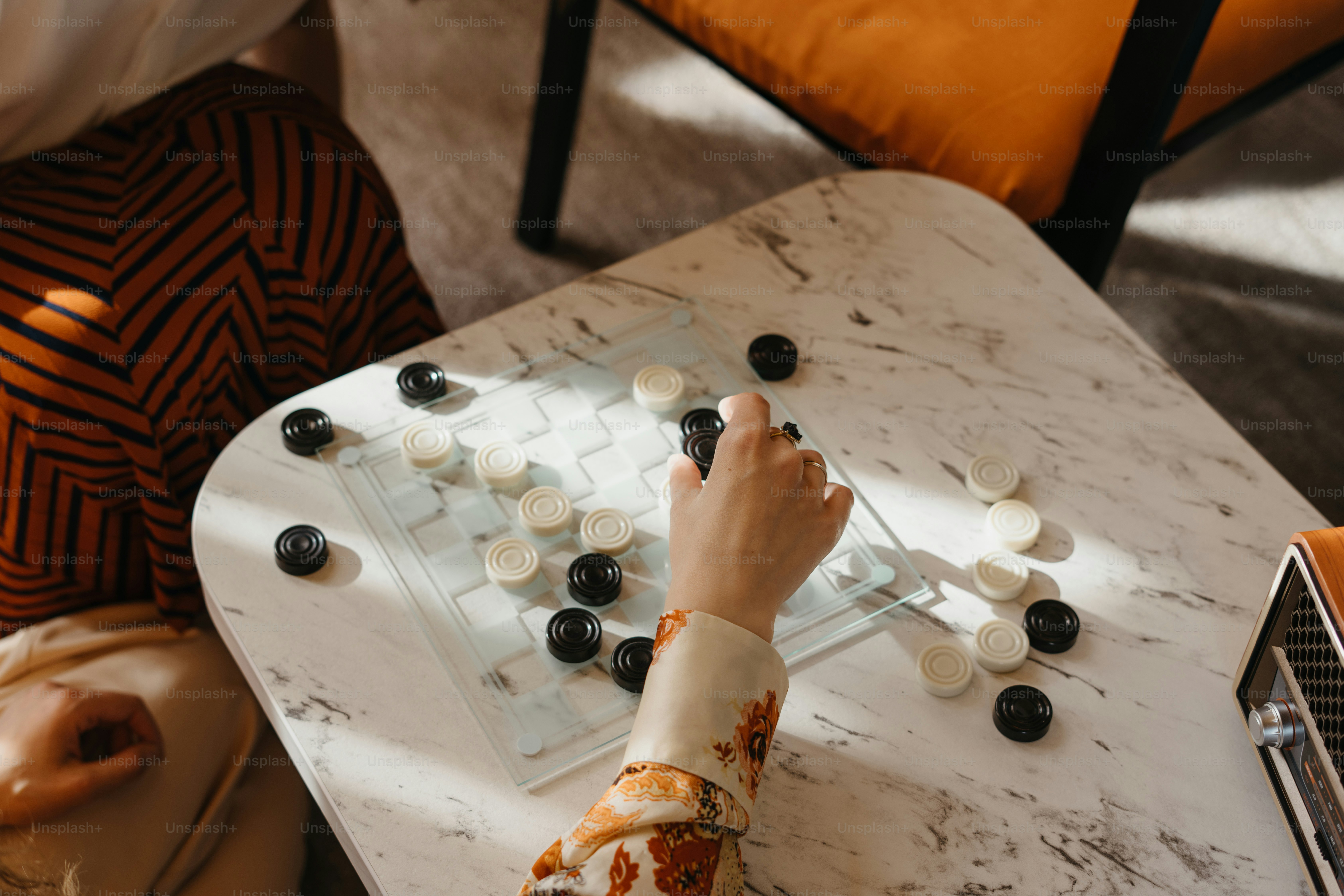 A person playing a game of checkers on a table photo – Game Image on ...