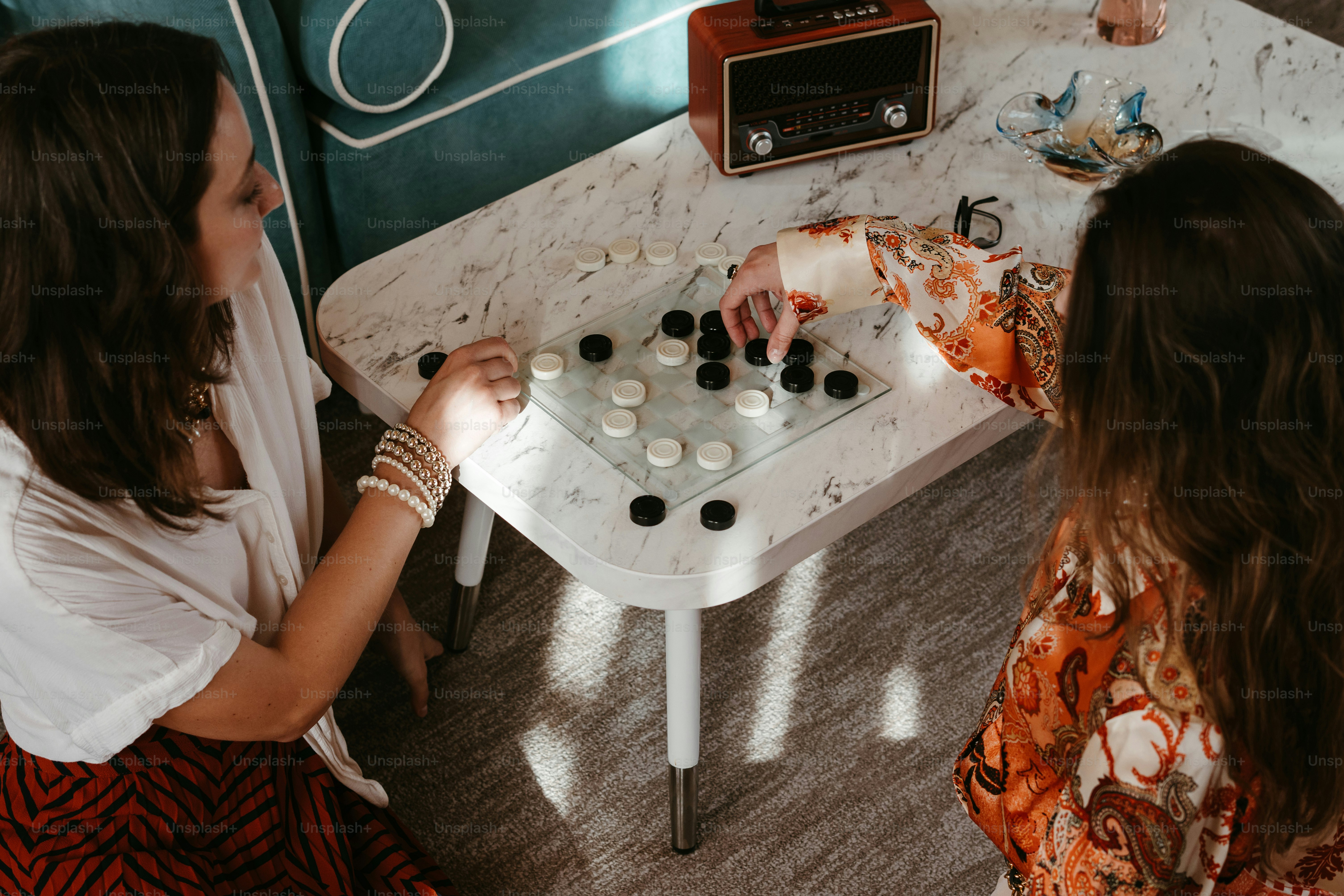 A couple of women playing a game of checkers photo – Table games Image ...