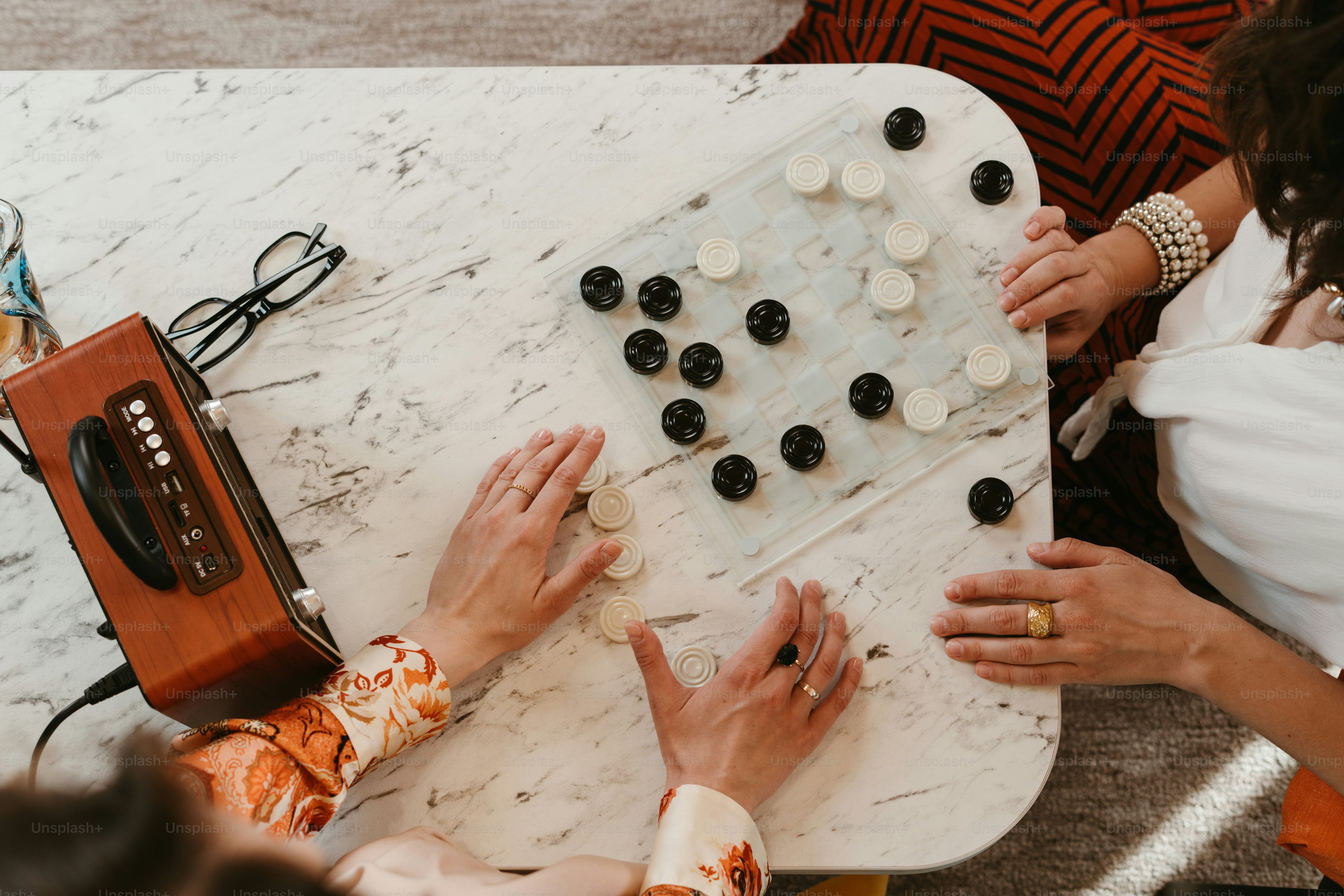 A person playing a game of checkers on a table photo – Game Image on ...