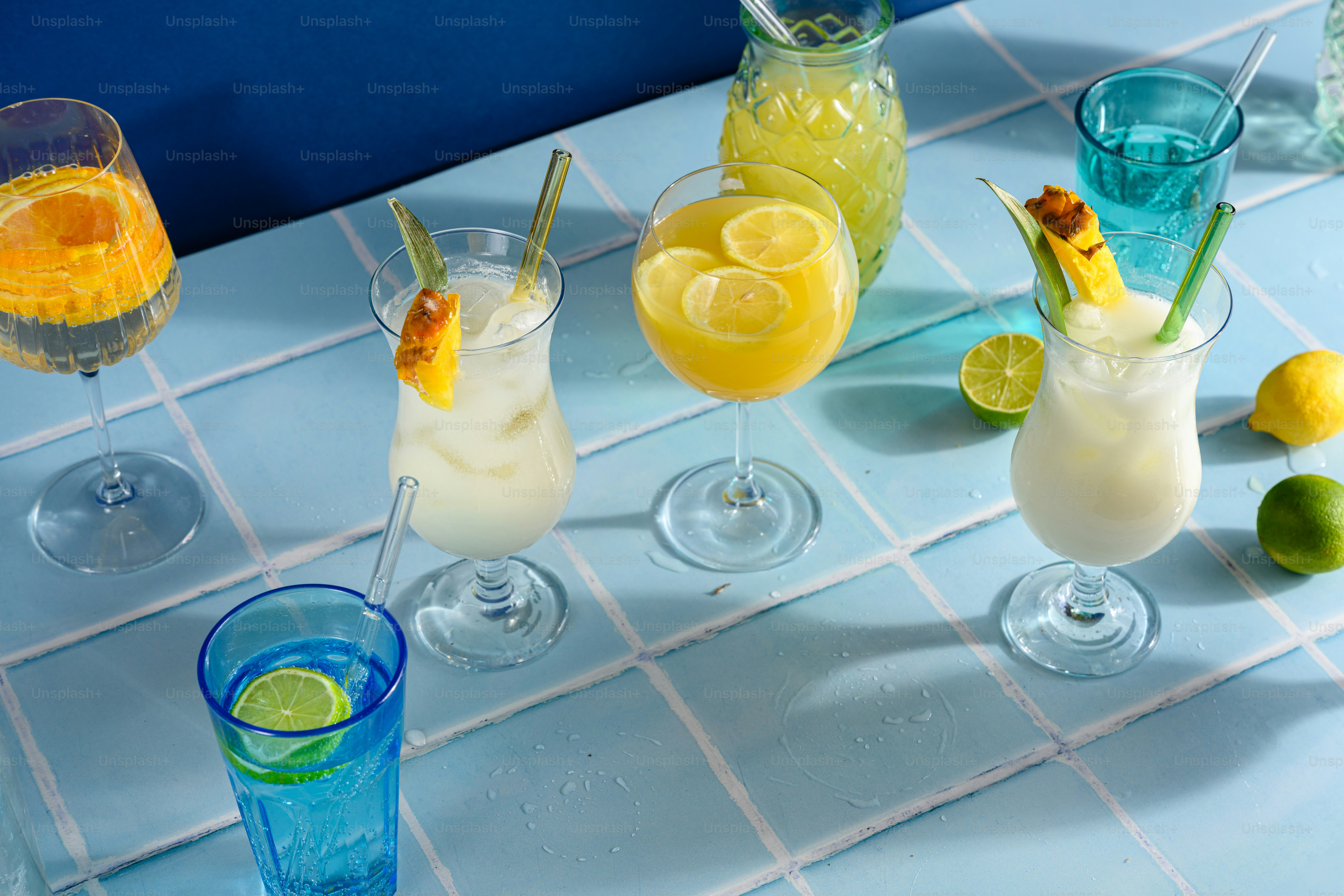 A table topped with glasses filled with different types of drinks photo ...