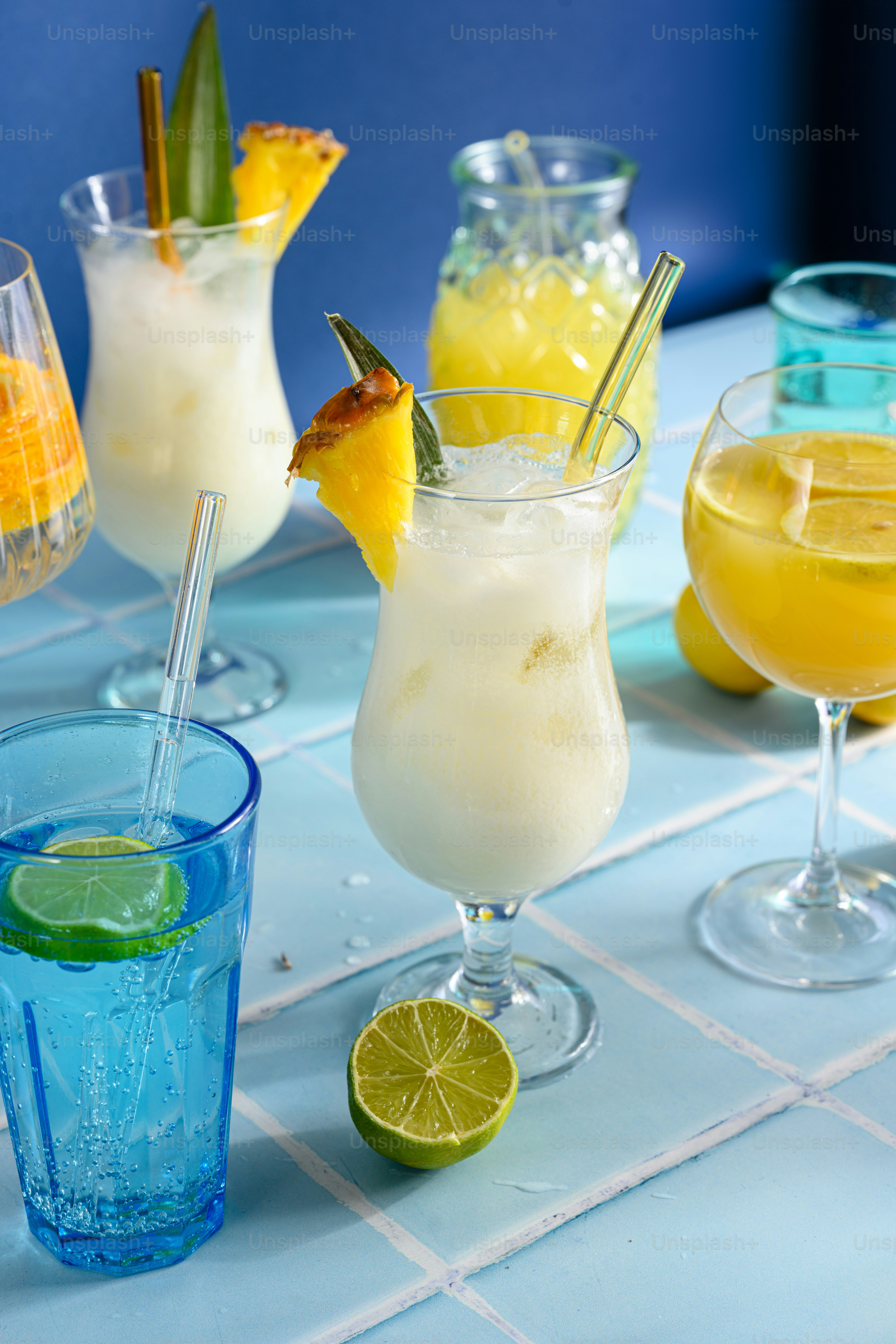 A table topped with glasses filled with different types of drinks photo ...