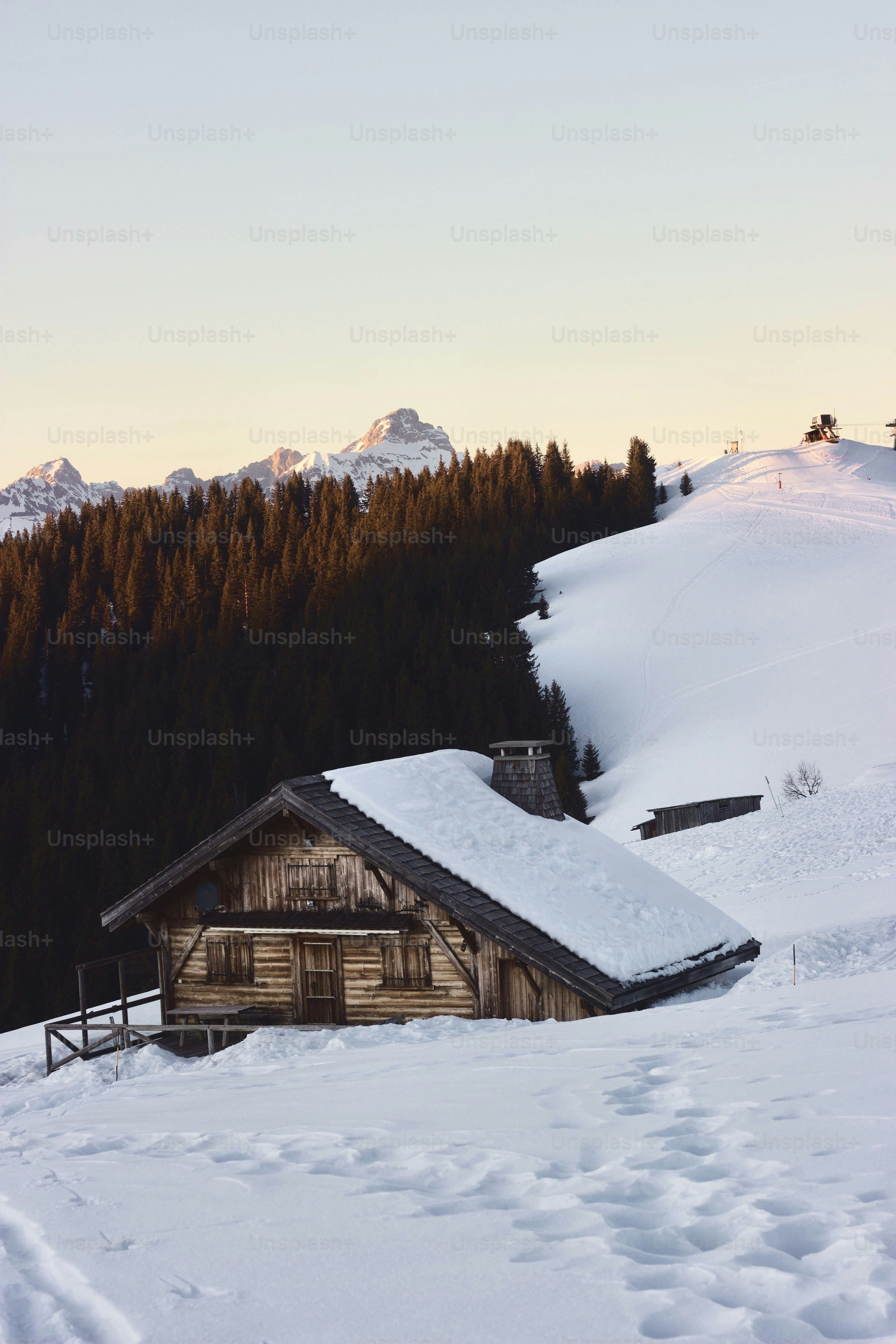 Une petite cabane au milieu d’une montagne enneigée photo – Image de ...