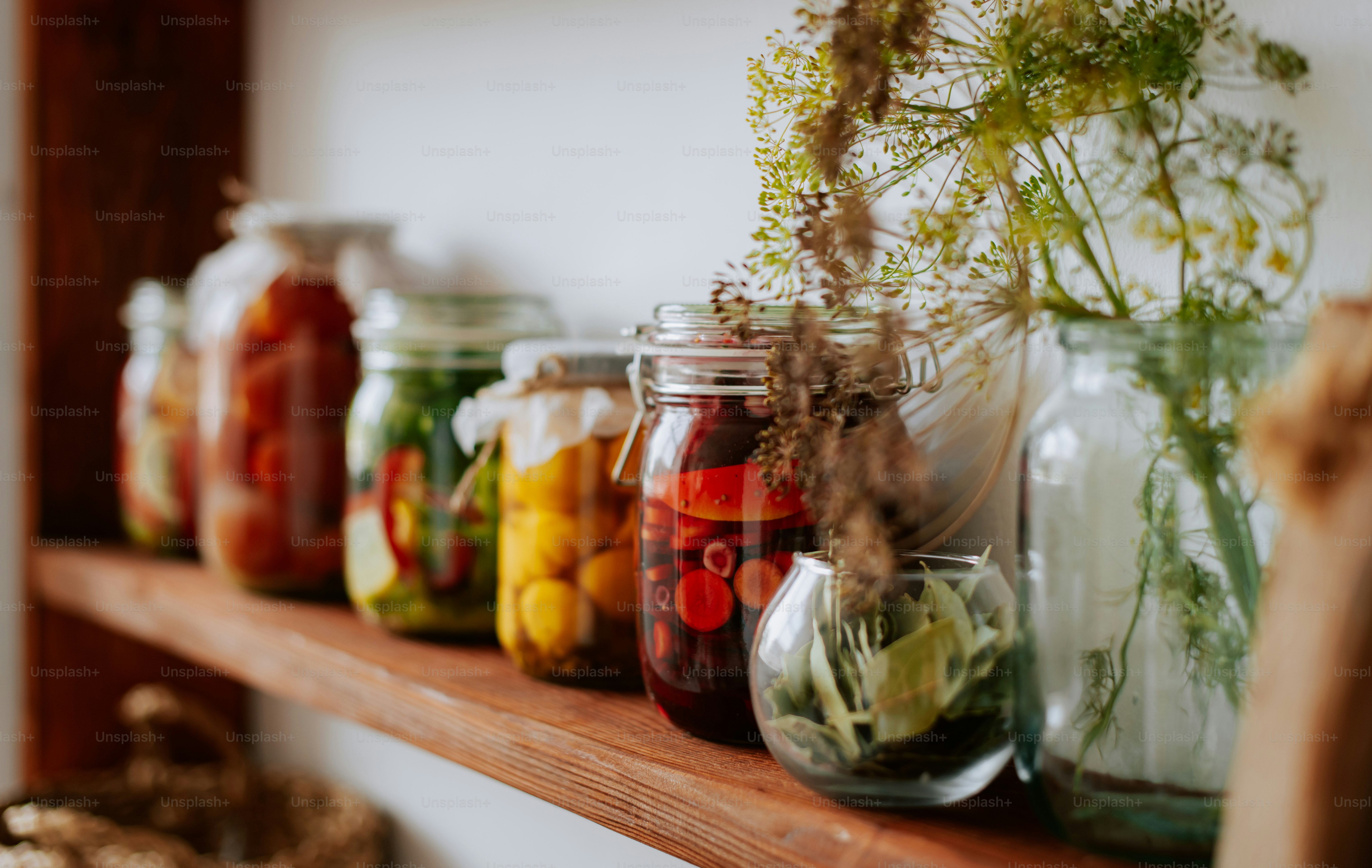 A shelf filled with jars filled with different types of food photo ...