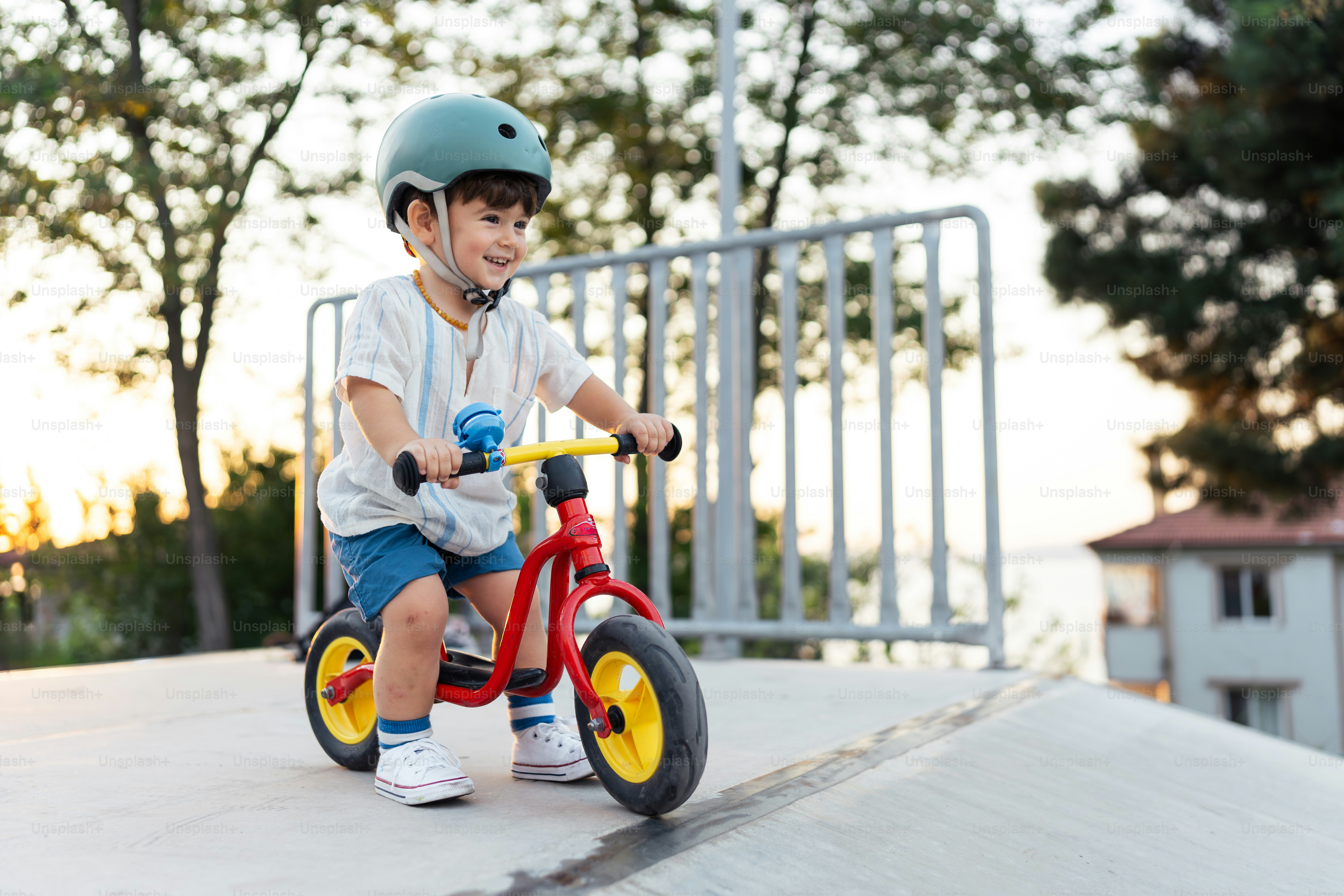 A young boy riding a red bike on top of a ramp photo – Outdoor Image on ...