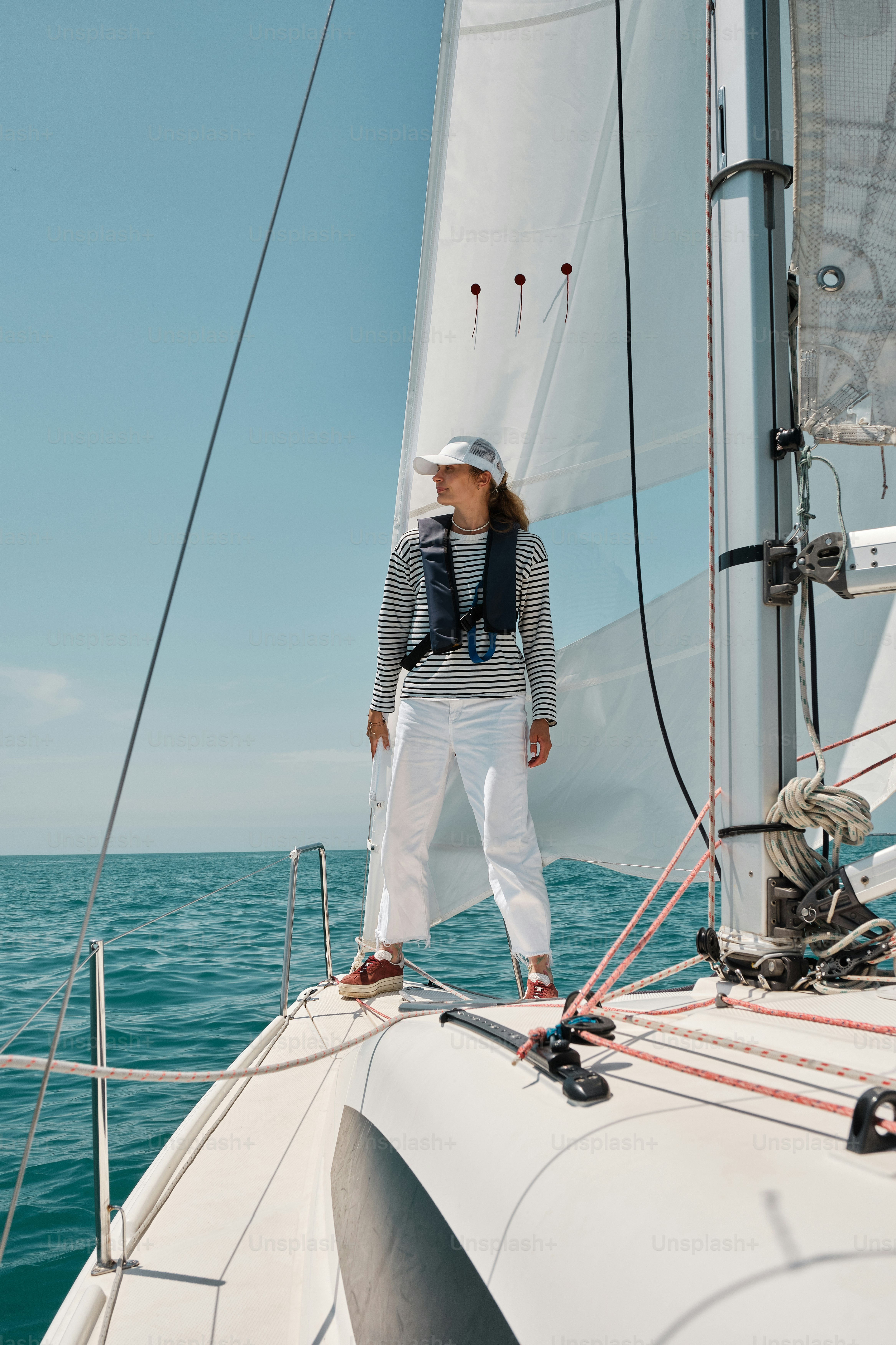 A man standing on the front of a sailboat photo – Sailing Image on Unsplash