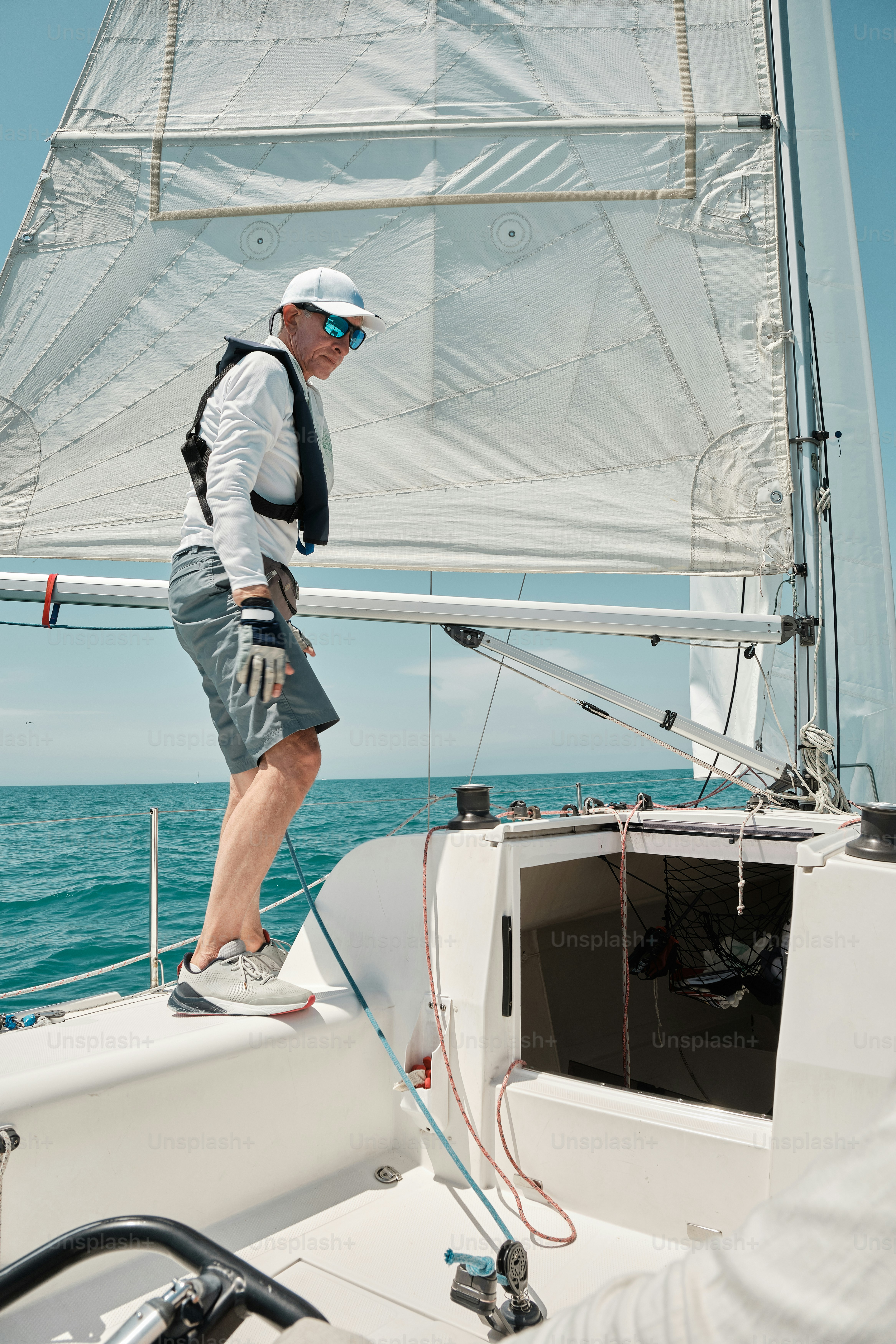 A man standing on the front of a sailboat photo – Boat Image on Unsplash