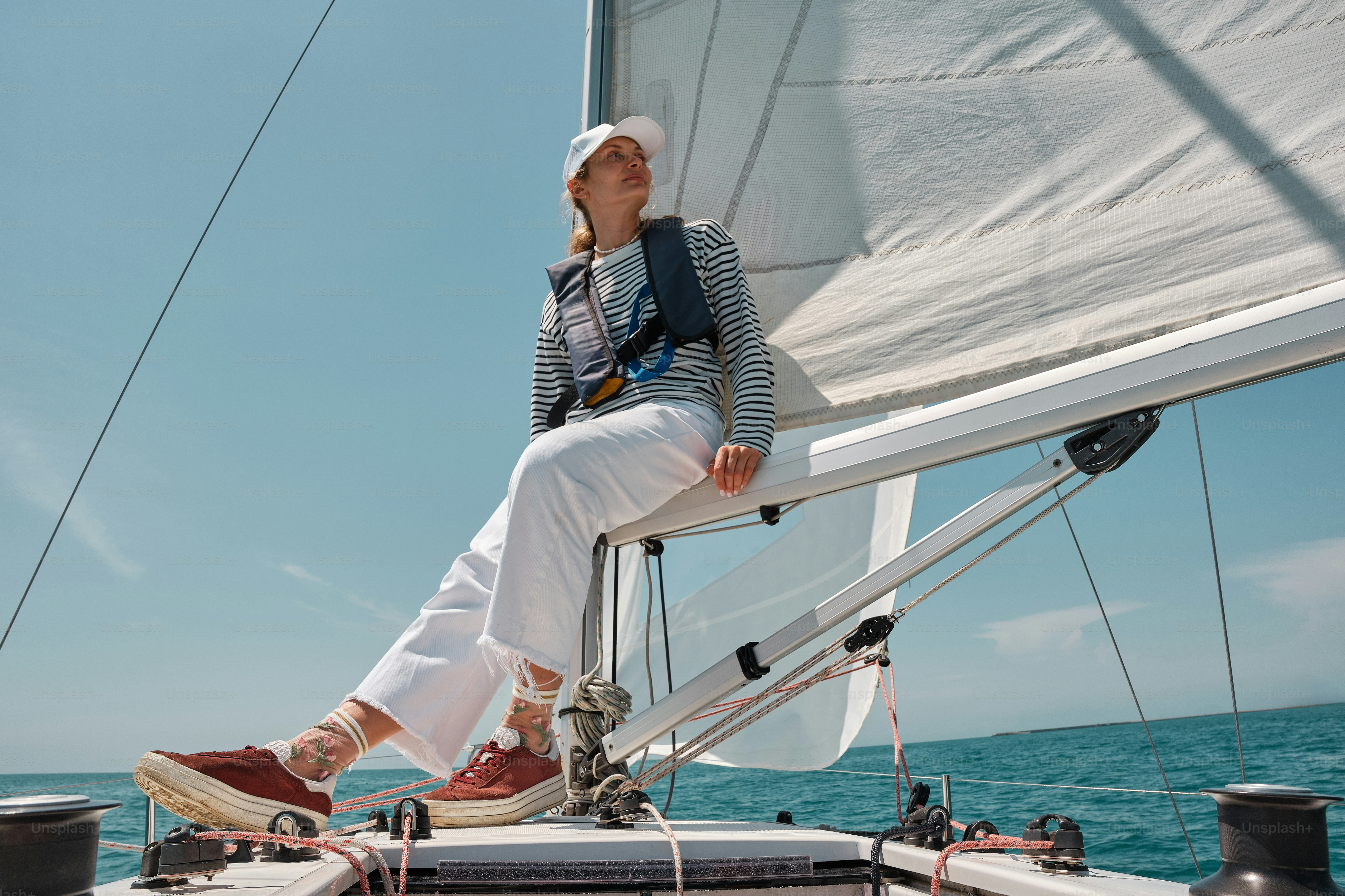 A man standing on the front of a sailboat photo – Sailing Image on Unsplash