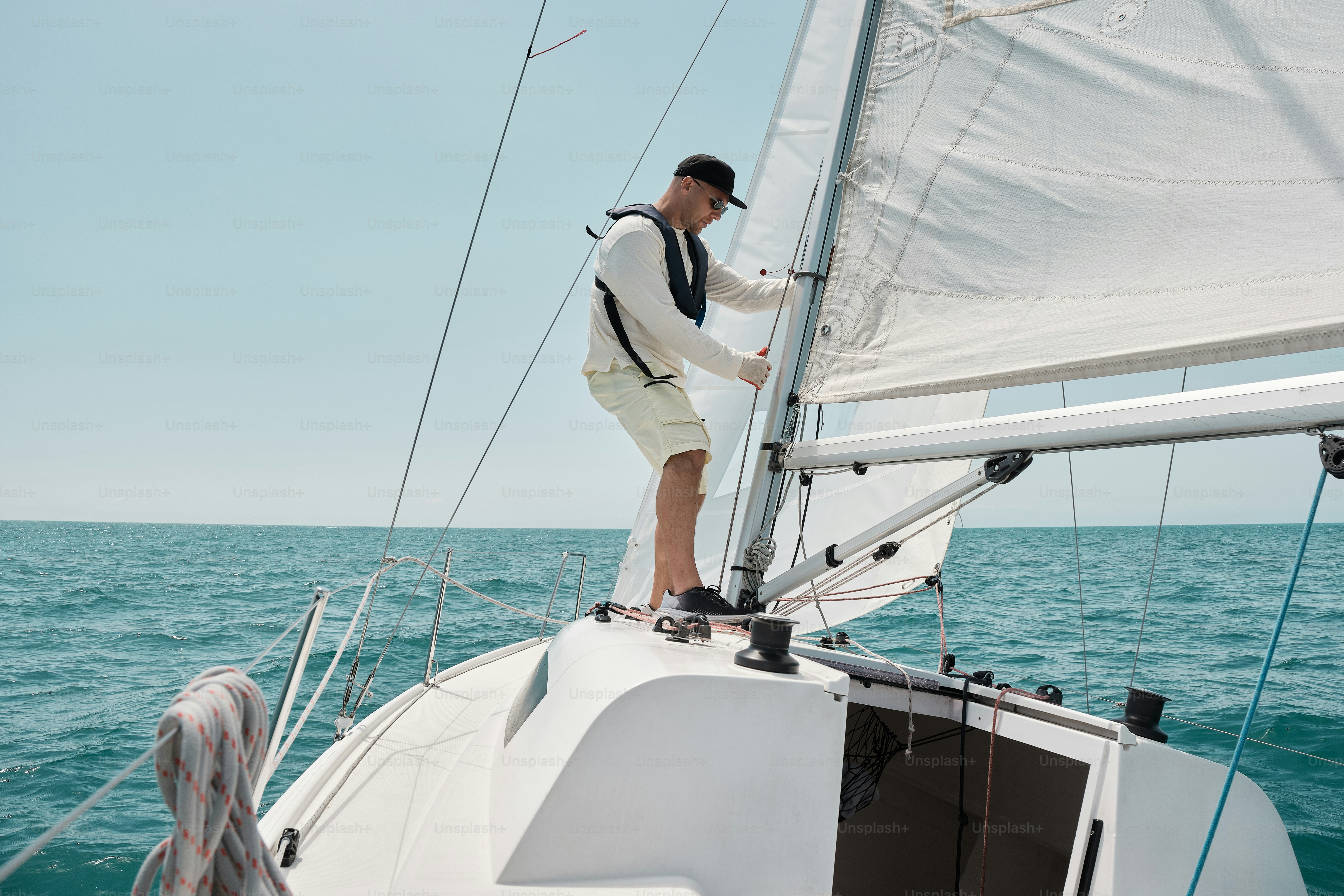 A man standing on the front of a sailboat photo – Sailing Image on Unsplash