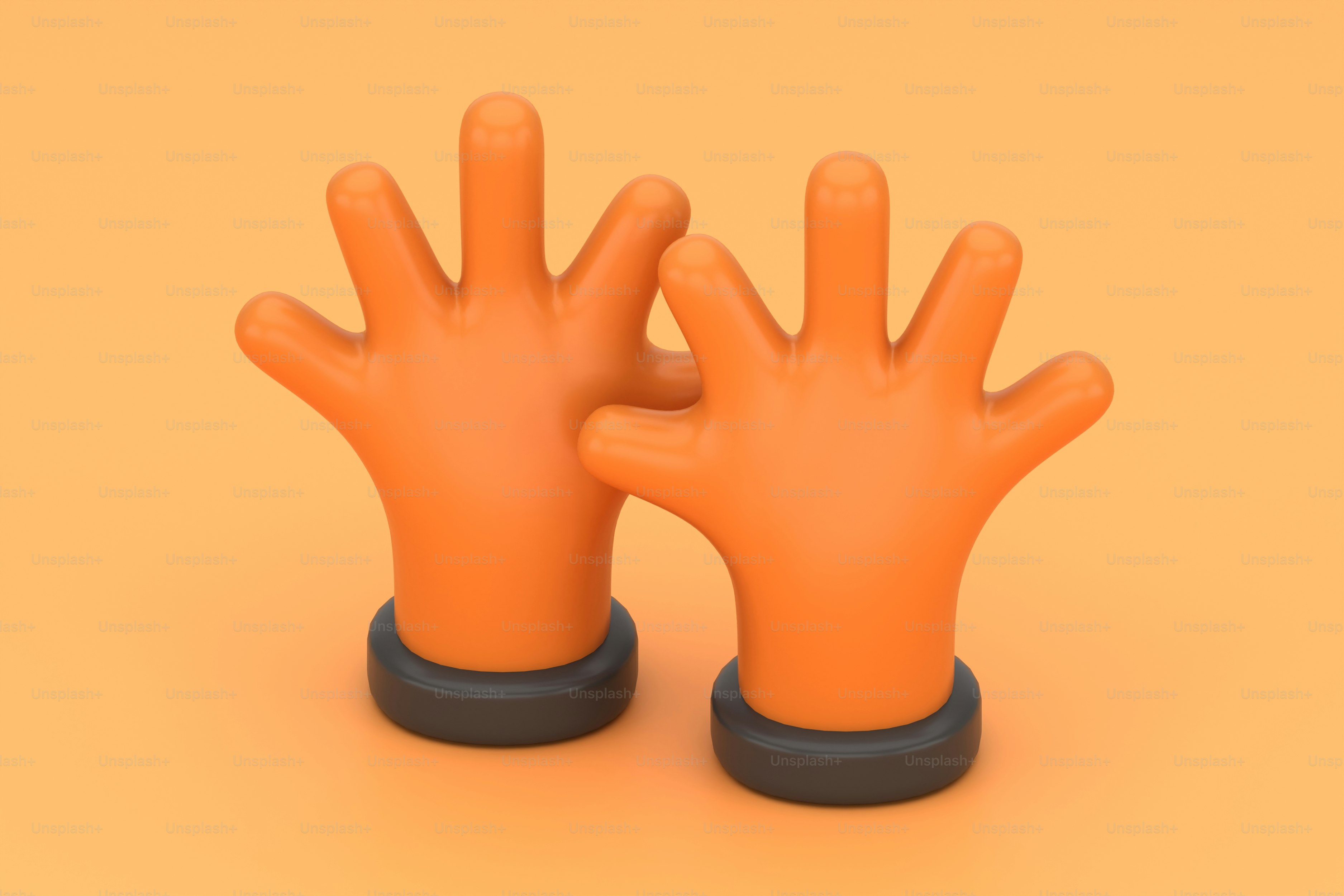 A pair of orange plastic hands on a yellow background photo ...