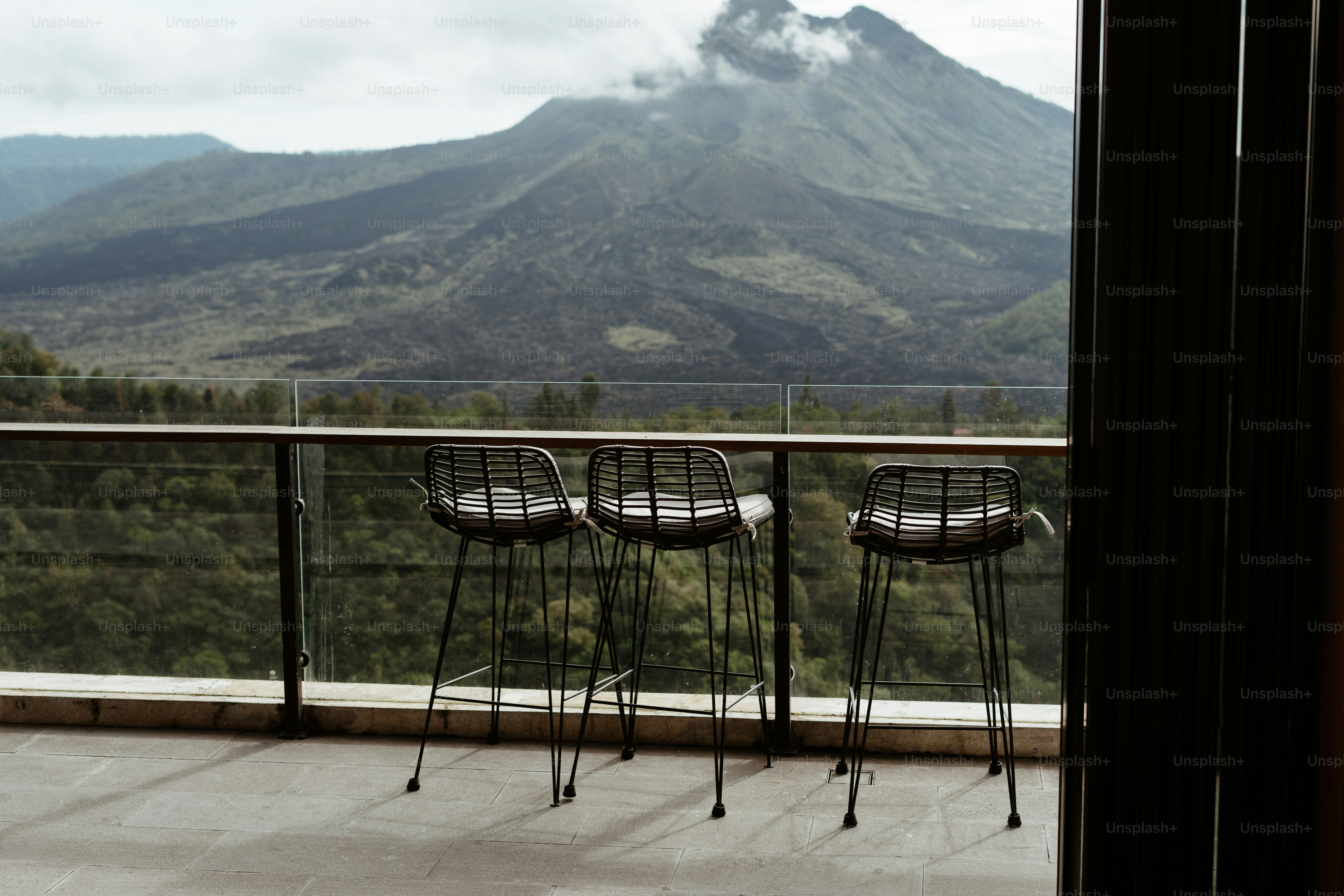 A balcony with a mountain view and bar stools photo – Volcano Image on ...