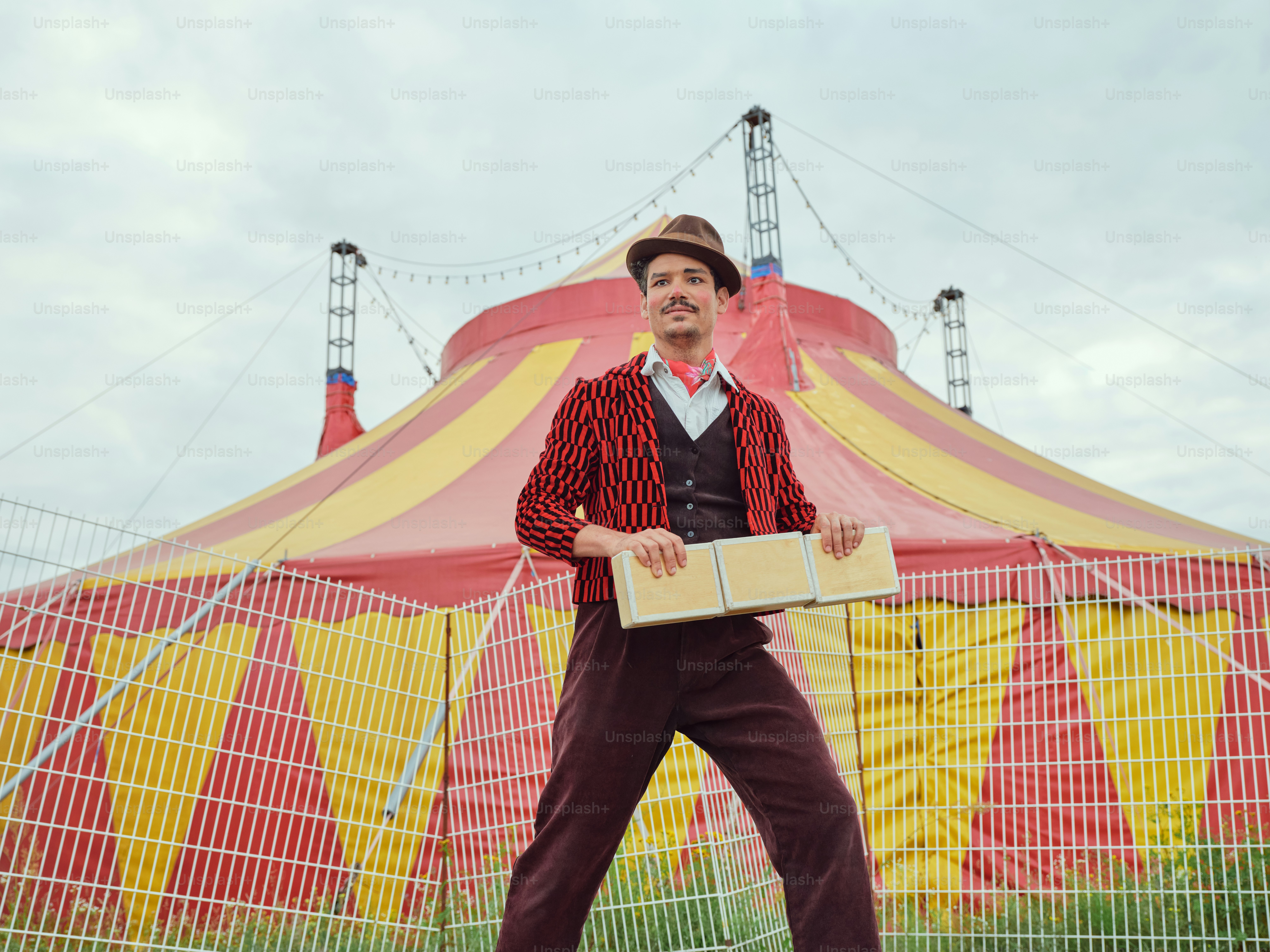 A man standing in front of a circus tent photo – Juggler Image on Unsplash