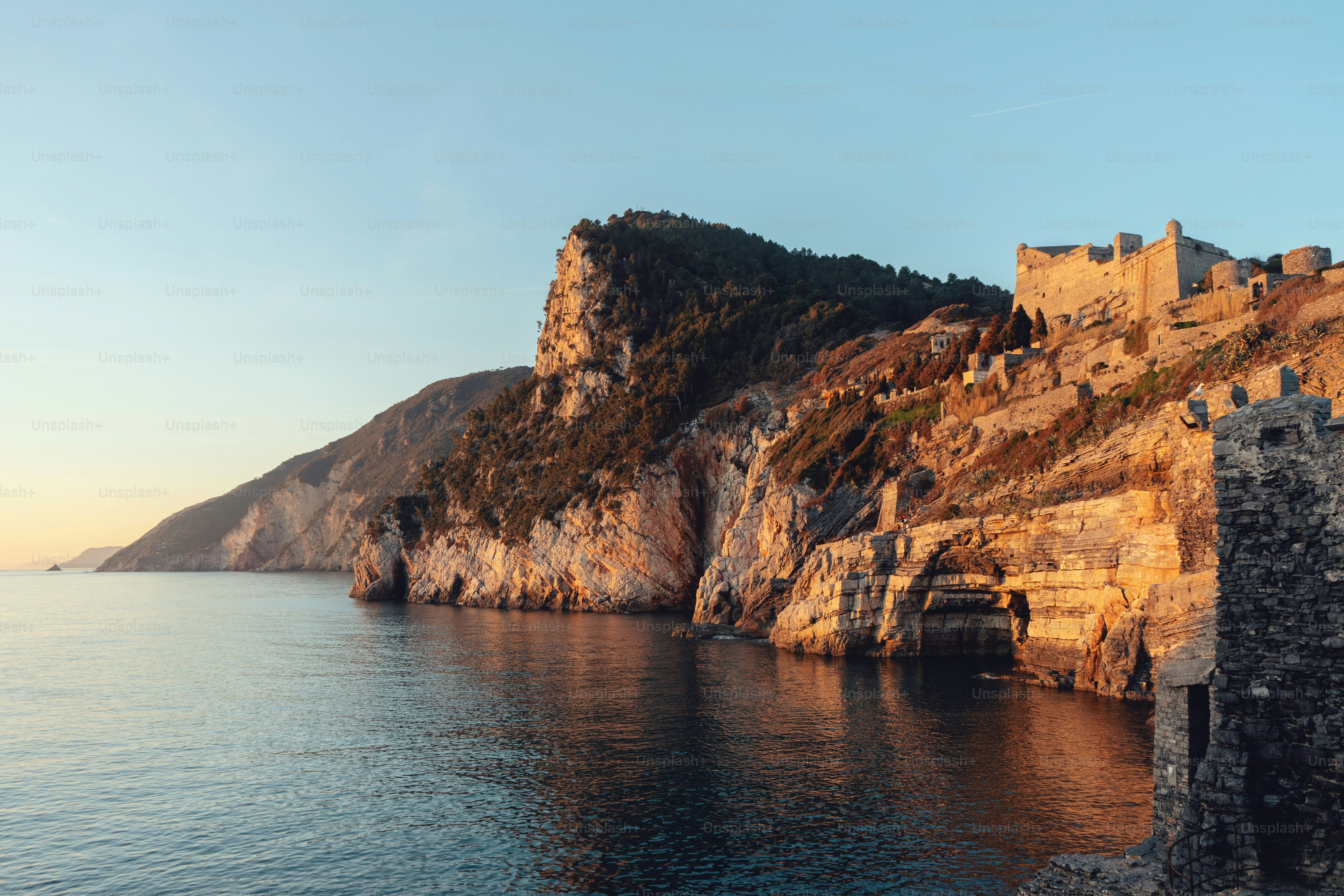 A castle sitting on top of a cliff next to the ocean photo ...