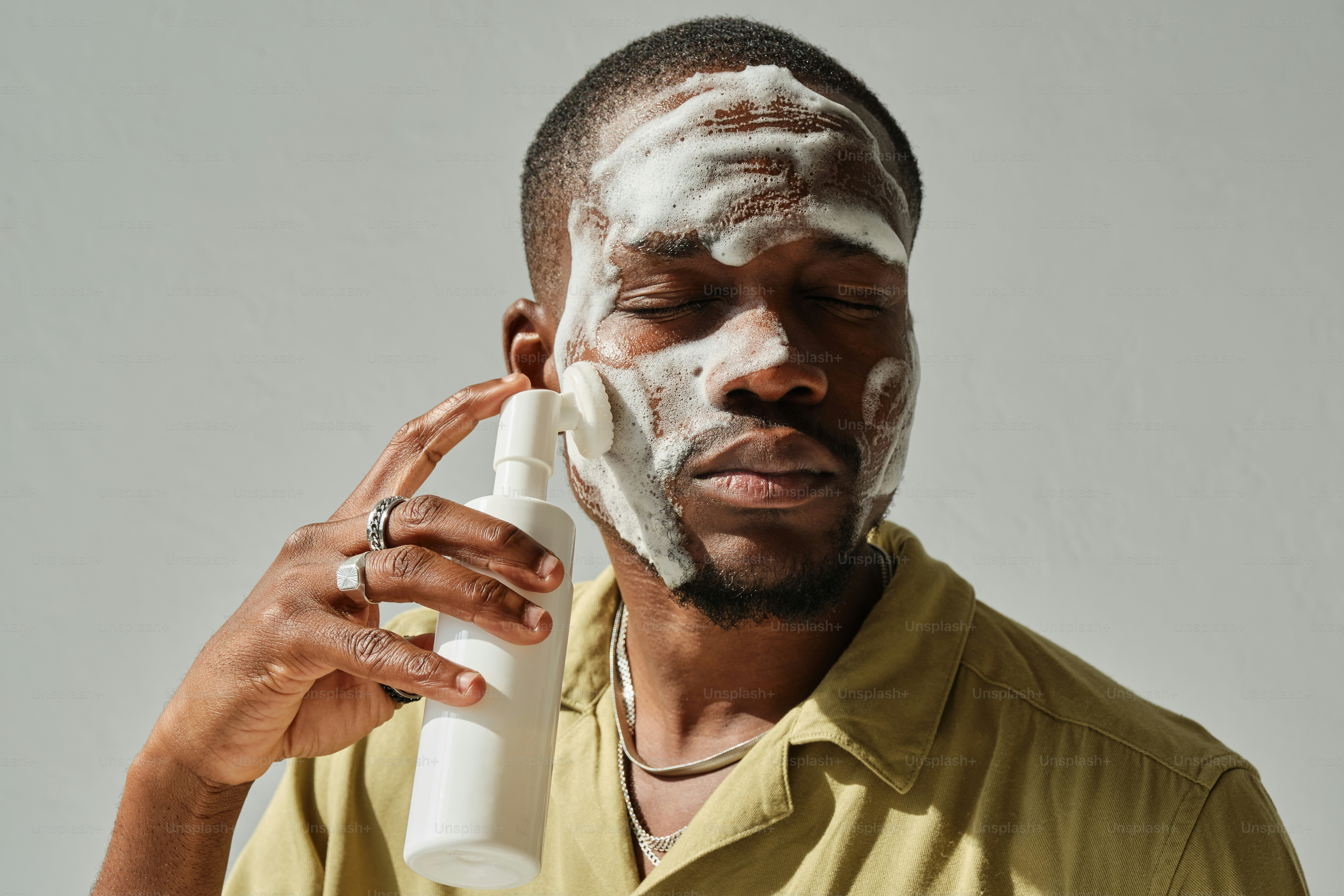 A man is shaving his face with a razor photo – Facial procedures Image ...
