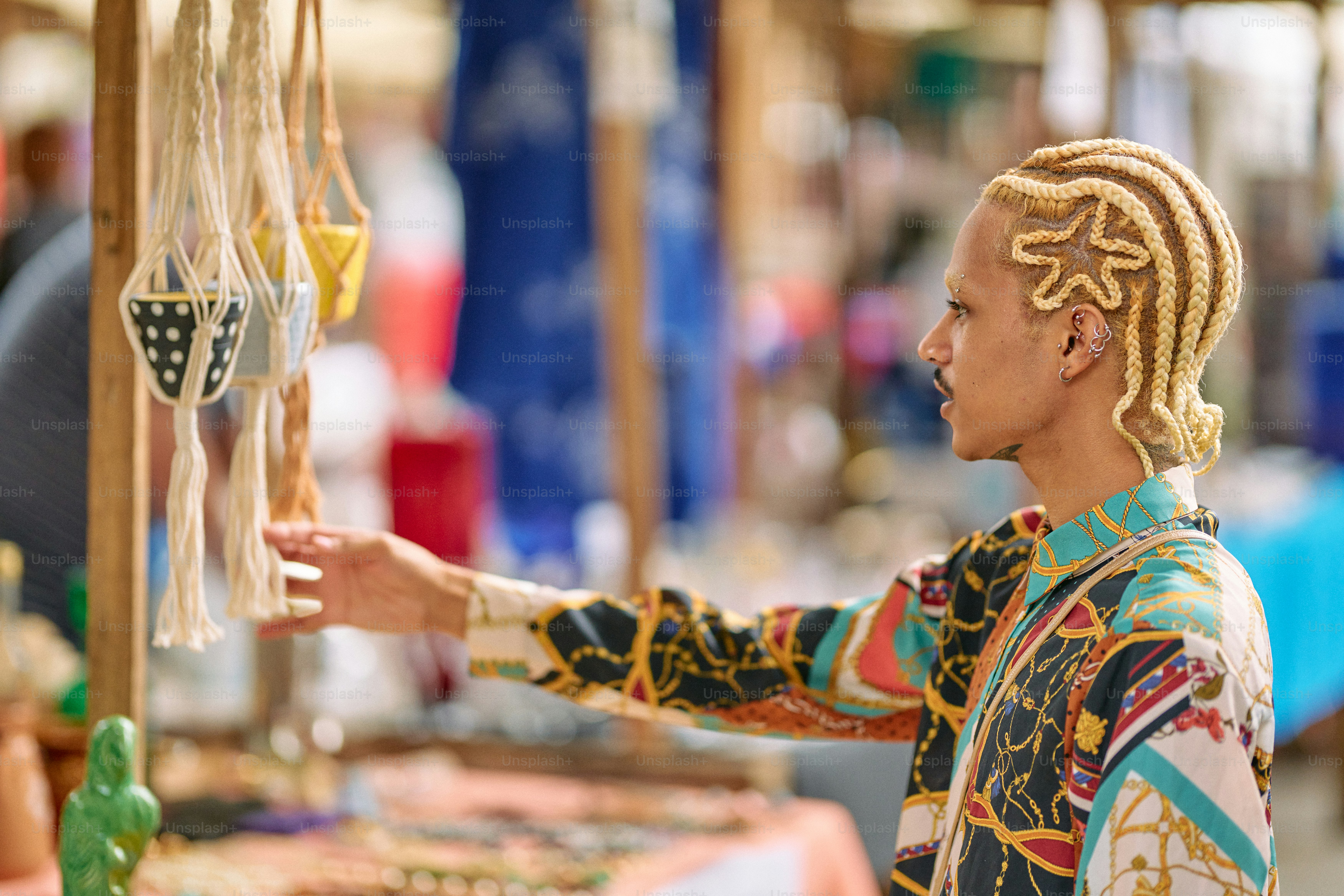 A man with dreadlocks looking at a display of jewelry photo – Street ...