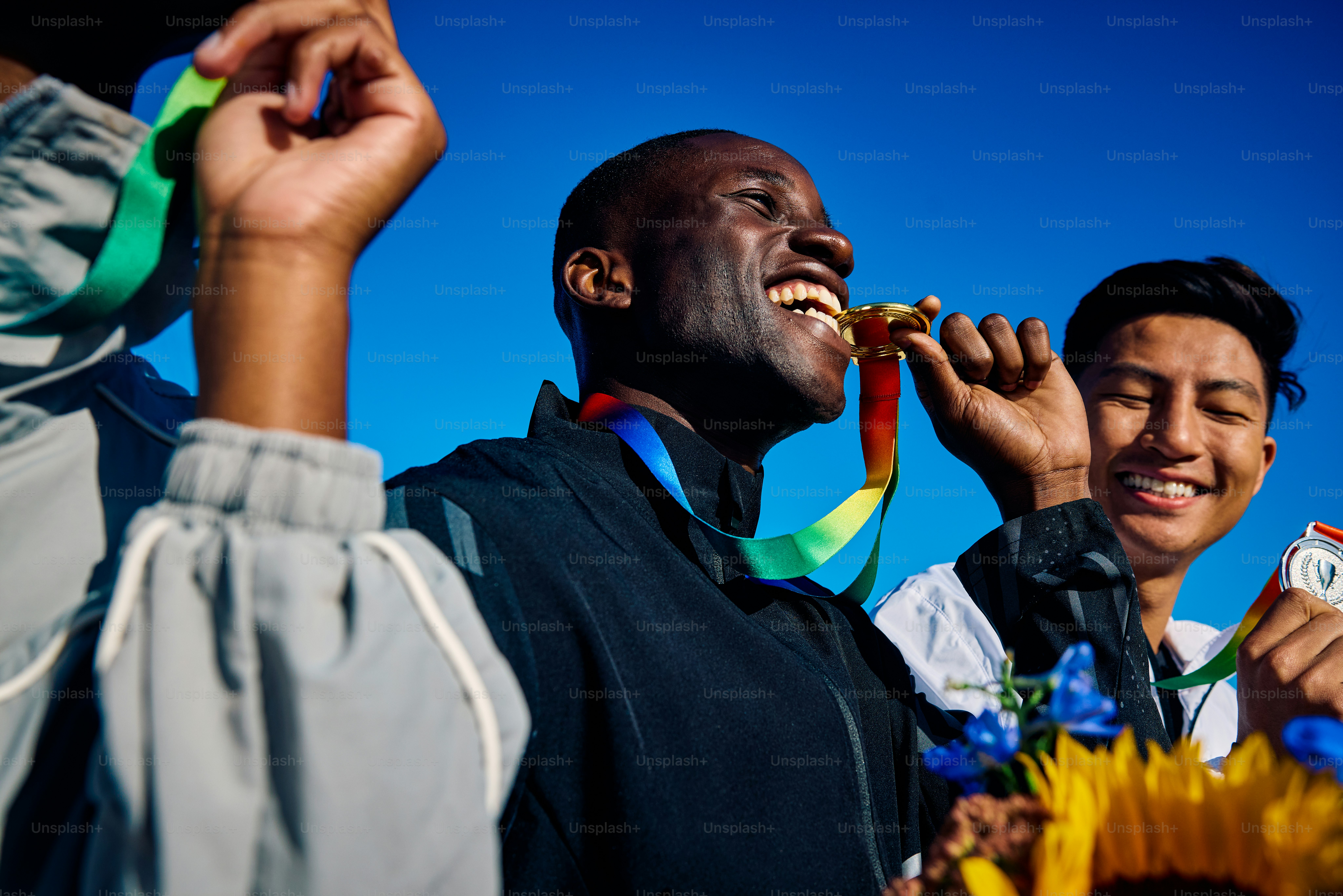 Group of International athletes with medals and bouquets celebrating ...