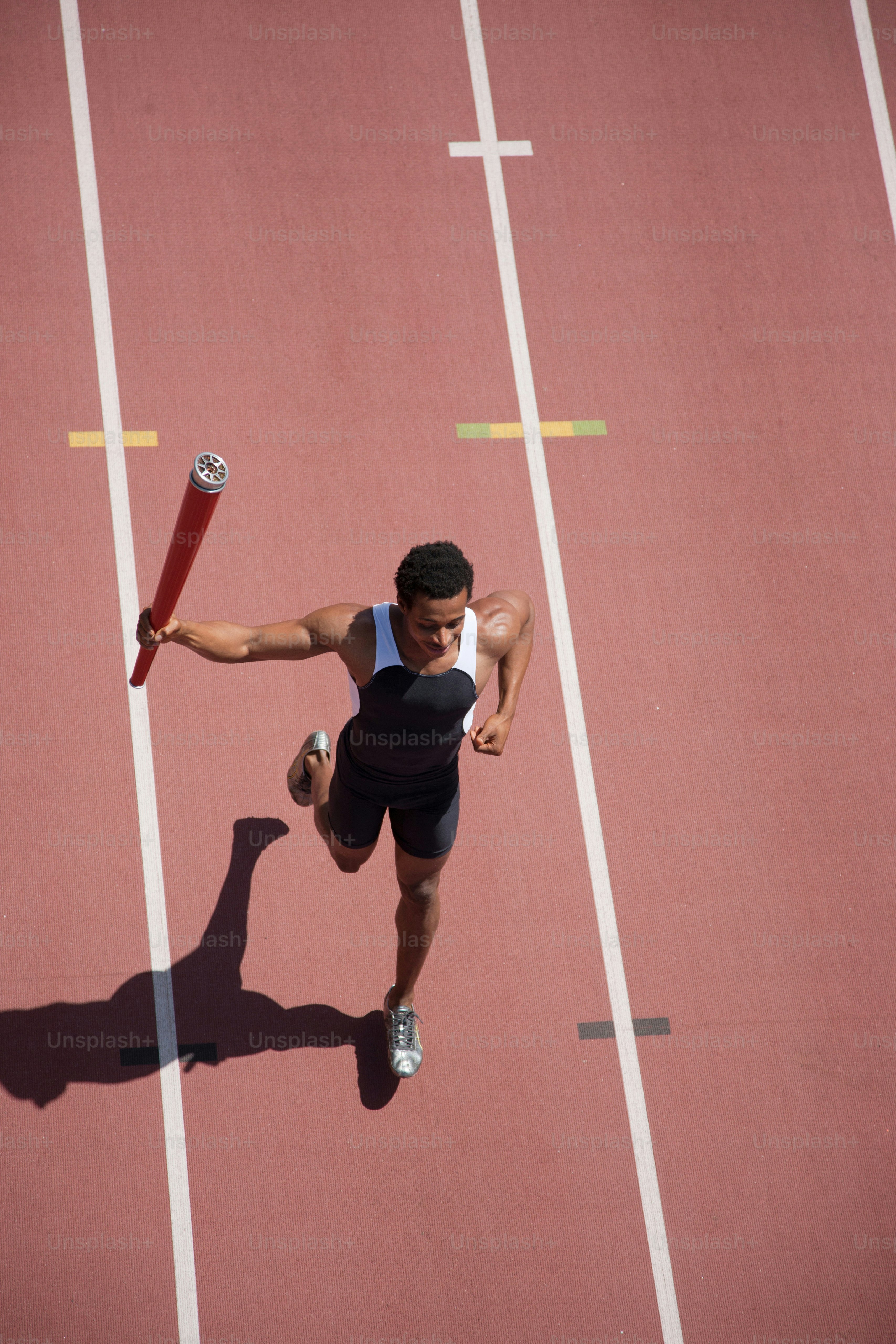 A man running on a track with a bat in his hand photo – Olympic games ...