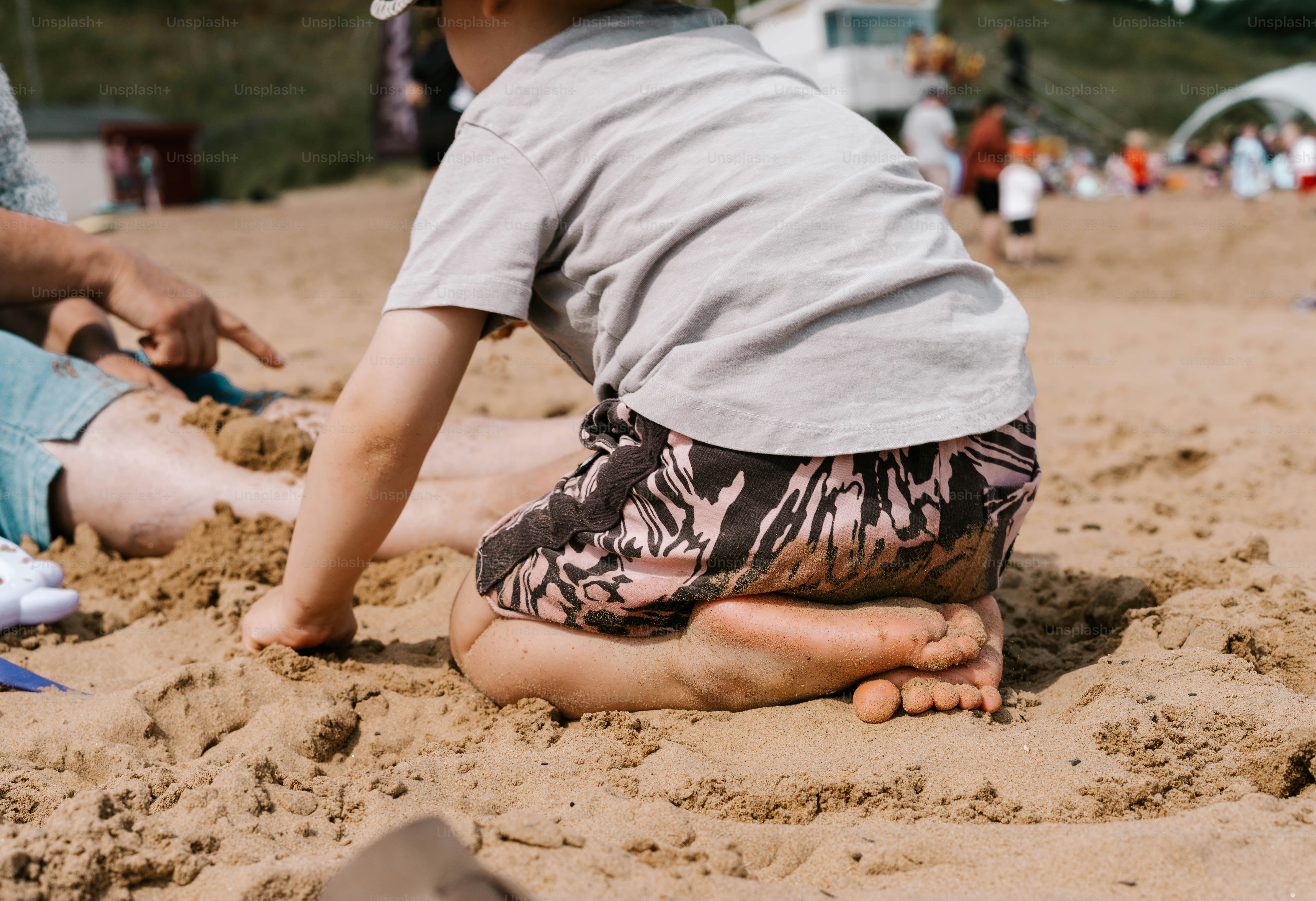A person standing in the sand with a smiley face drawn in the sand ...