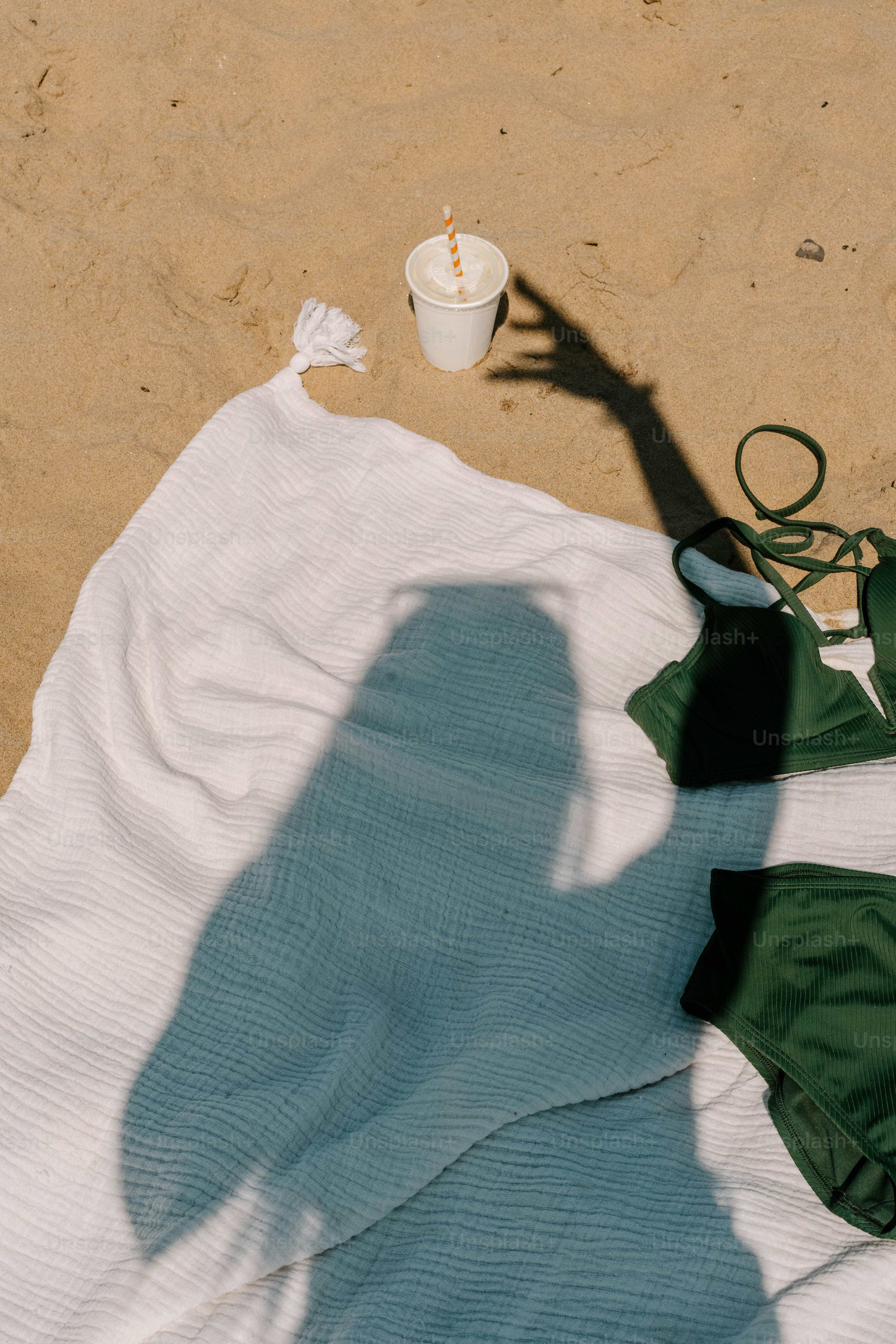 A woman in a green and white bathing suit on the beach photo – Shadow ...