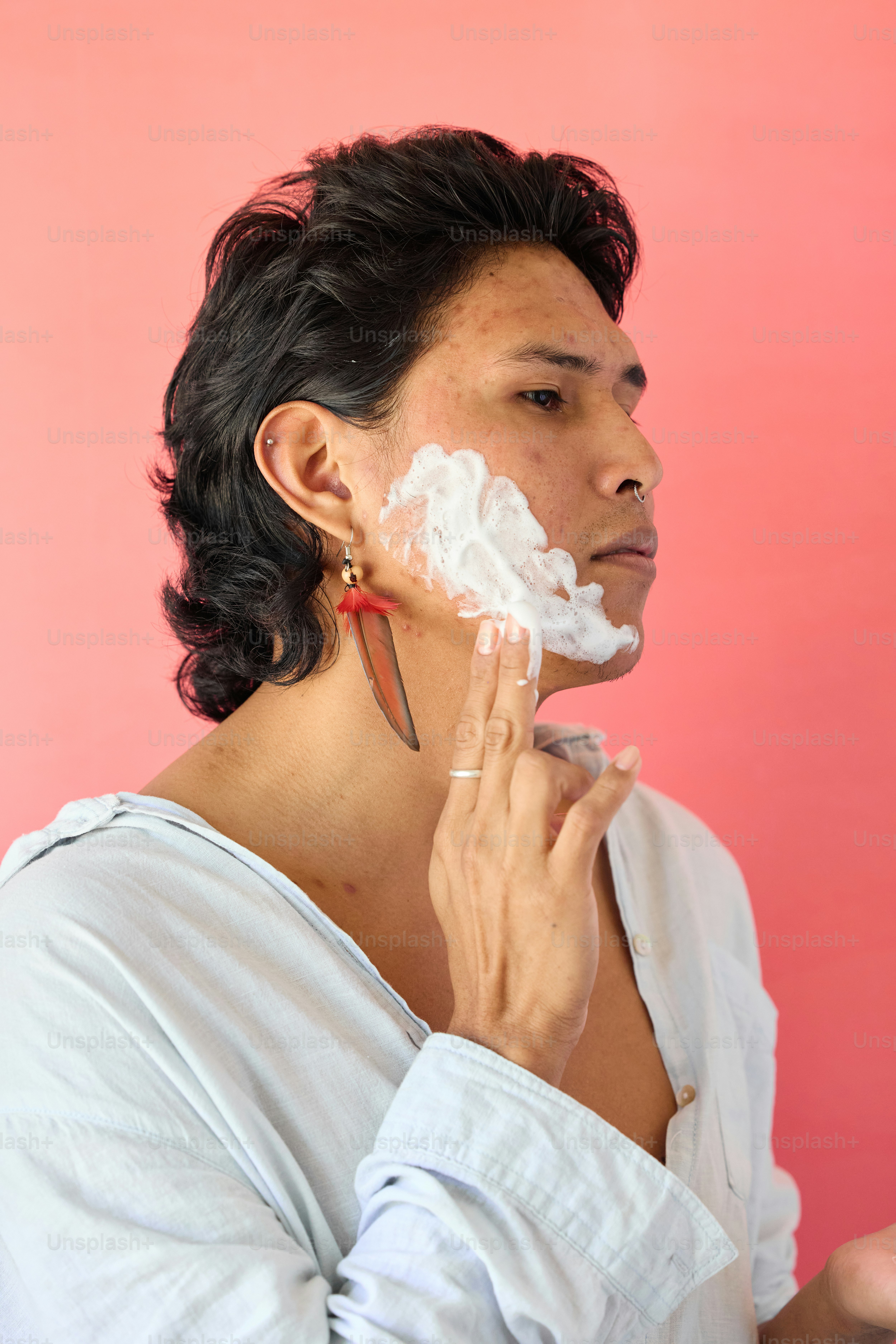 A woman is shaving her face with a shaving razor photo – Selfcare Image ...