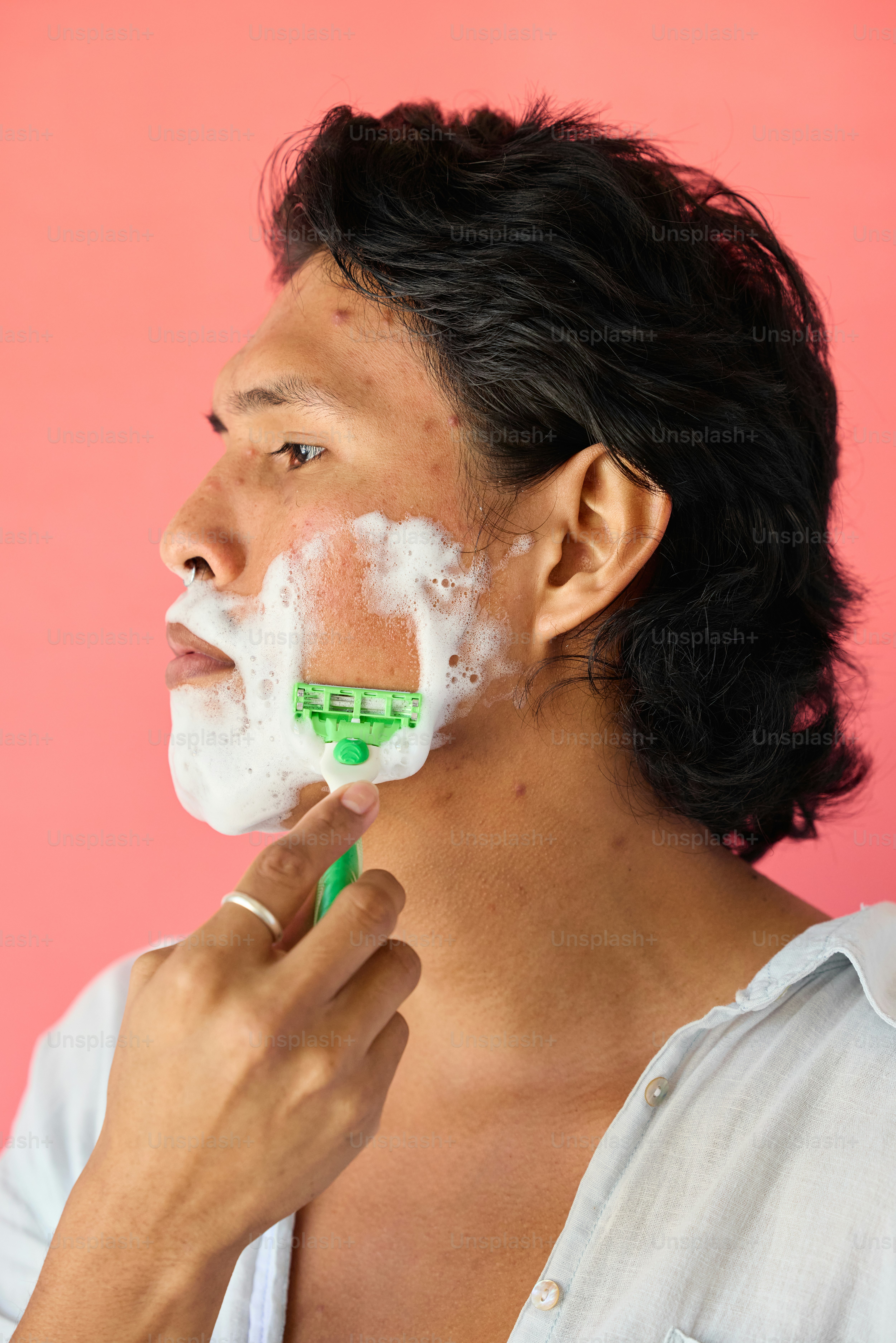 A man shaving his face with a green toothbrush photo – Shaving Image on ...