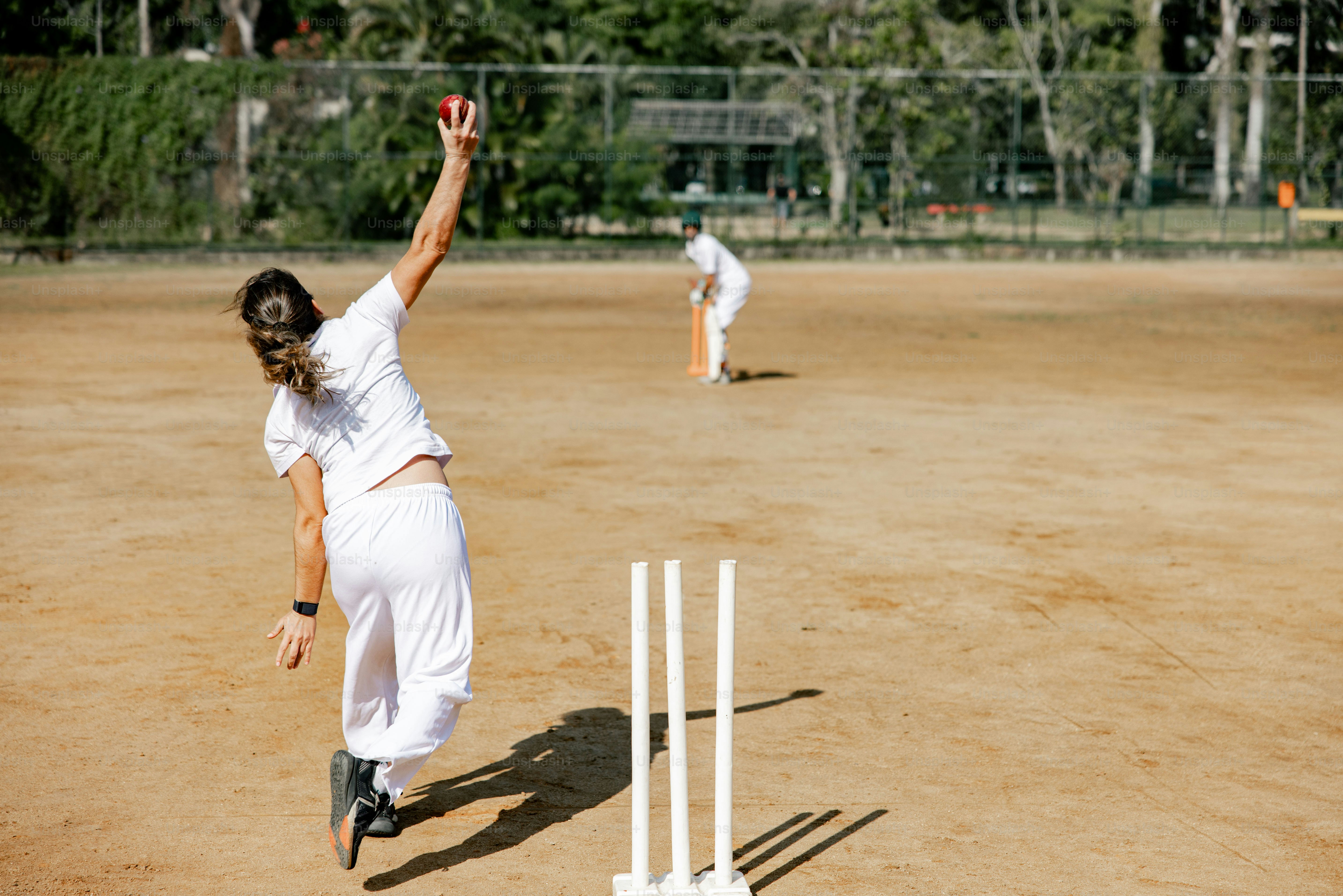 A woman in white throwing a ball towards a tee photo – Teamwork Image ...