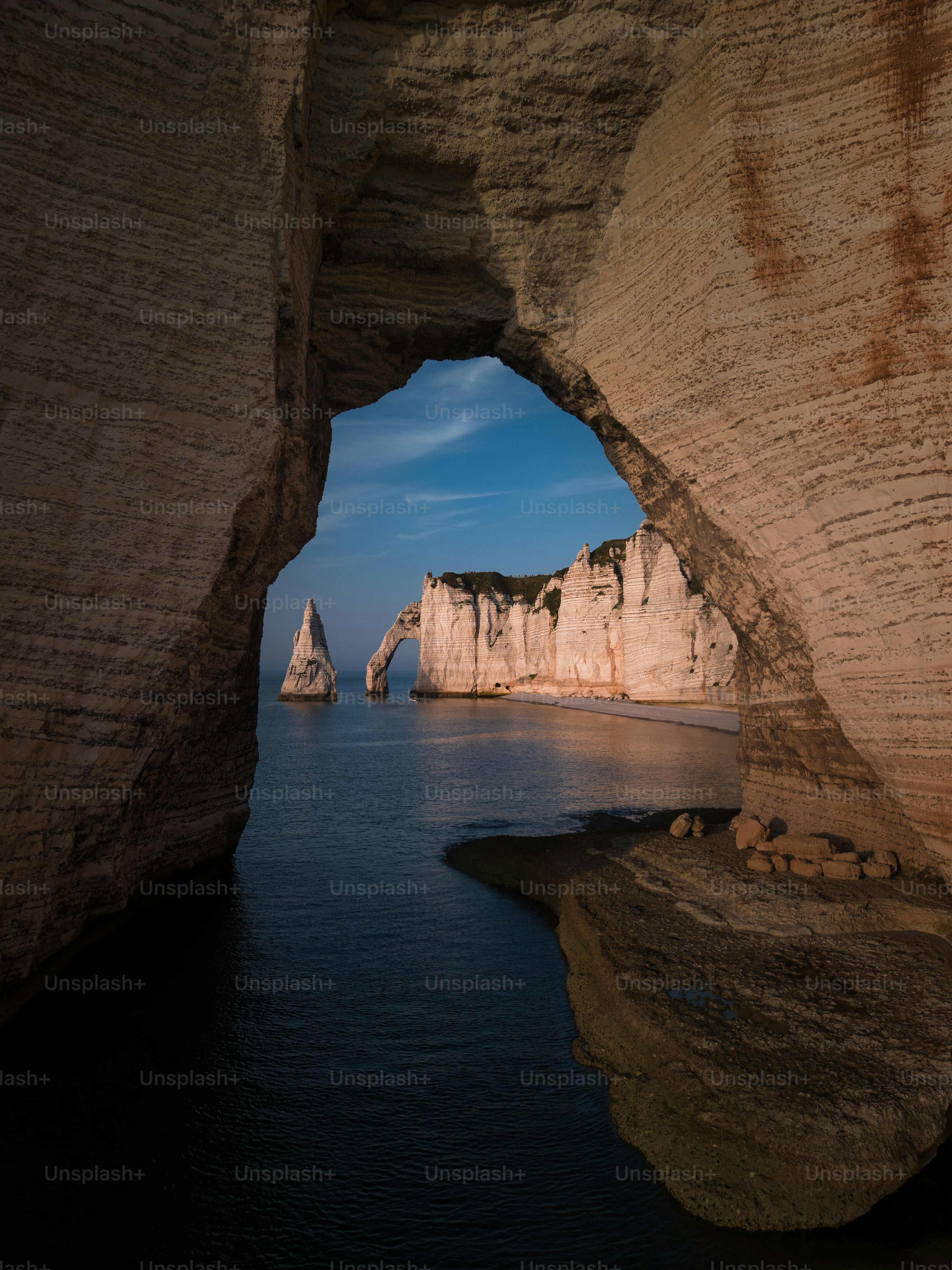 A view of a body of water from inside a cave photo – Sea Image on Unsplash