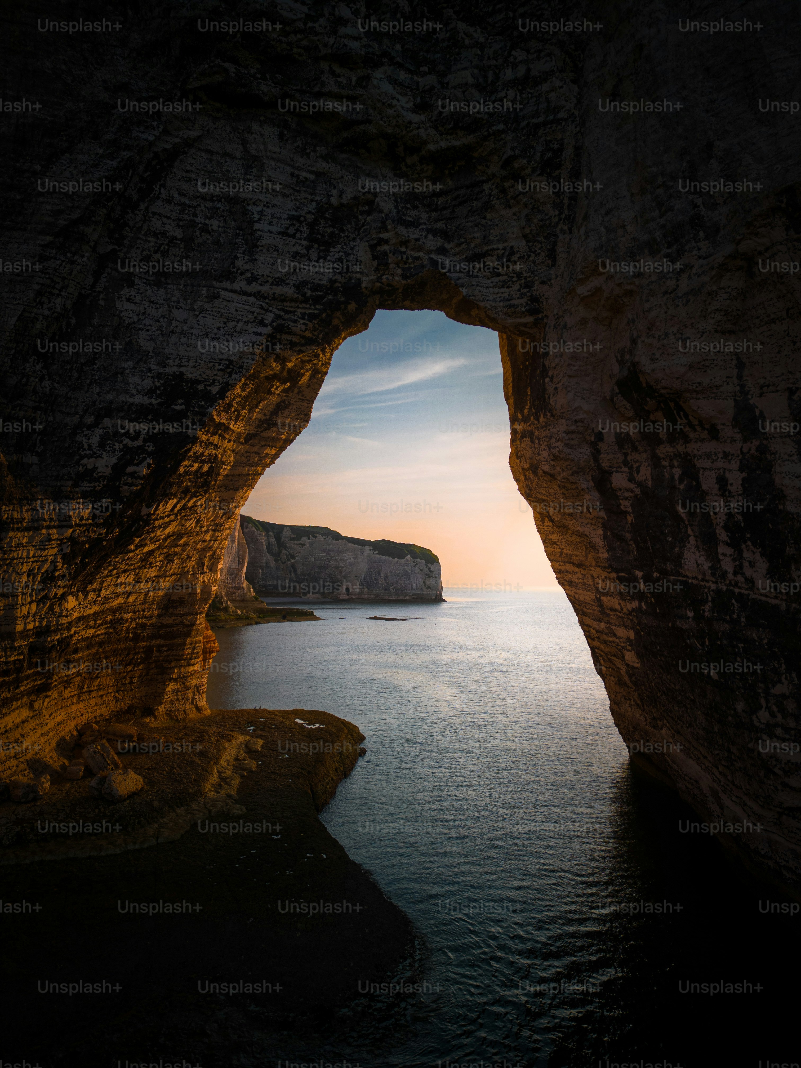 A view of a body of water from inside a cave photo – Sea Image on Unsplash