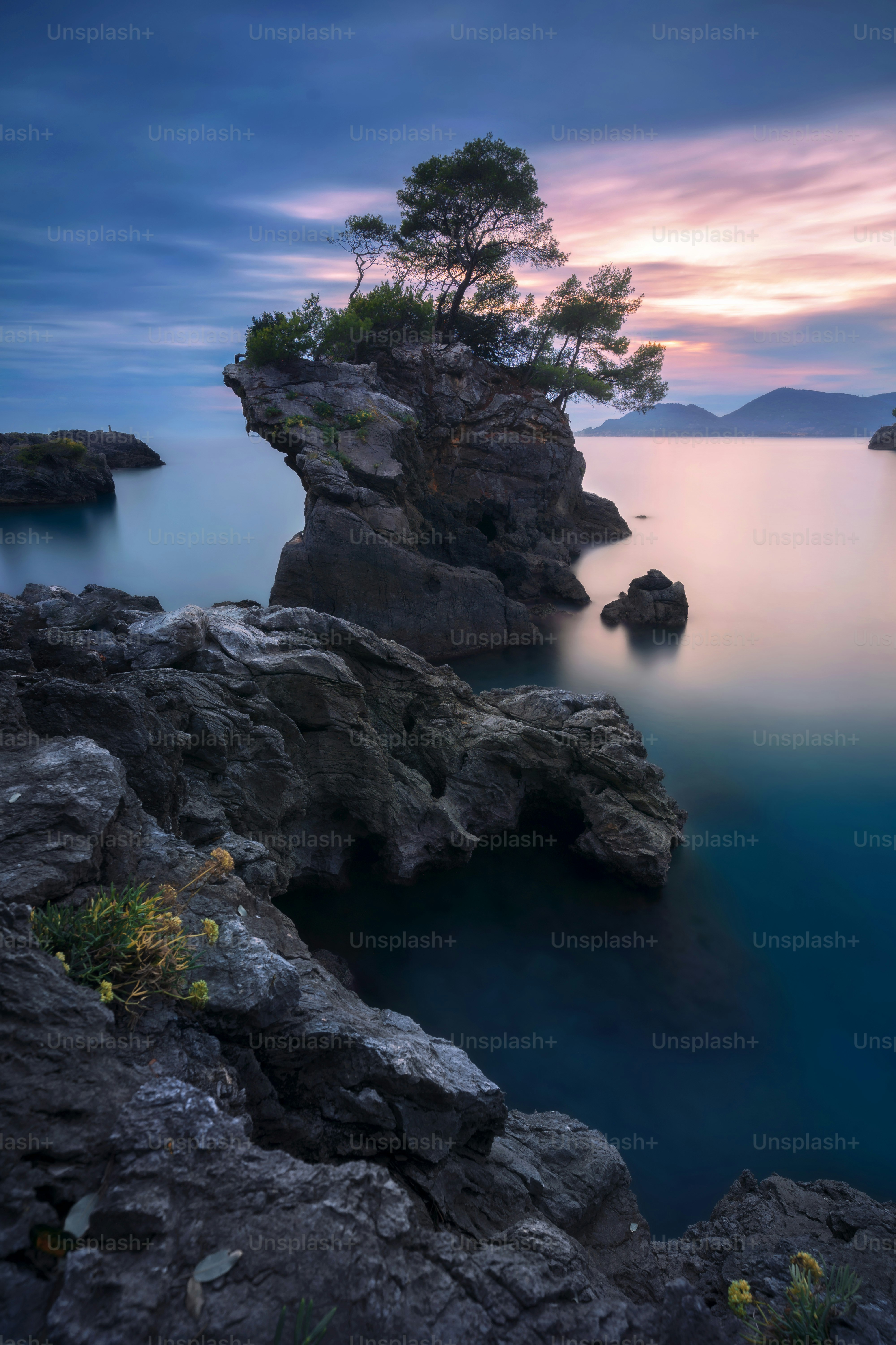 A body of water surrounded by rocks and trees photo – Lerici Image on ...