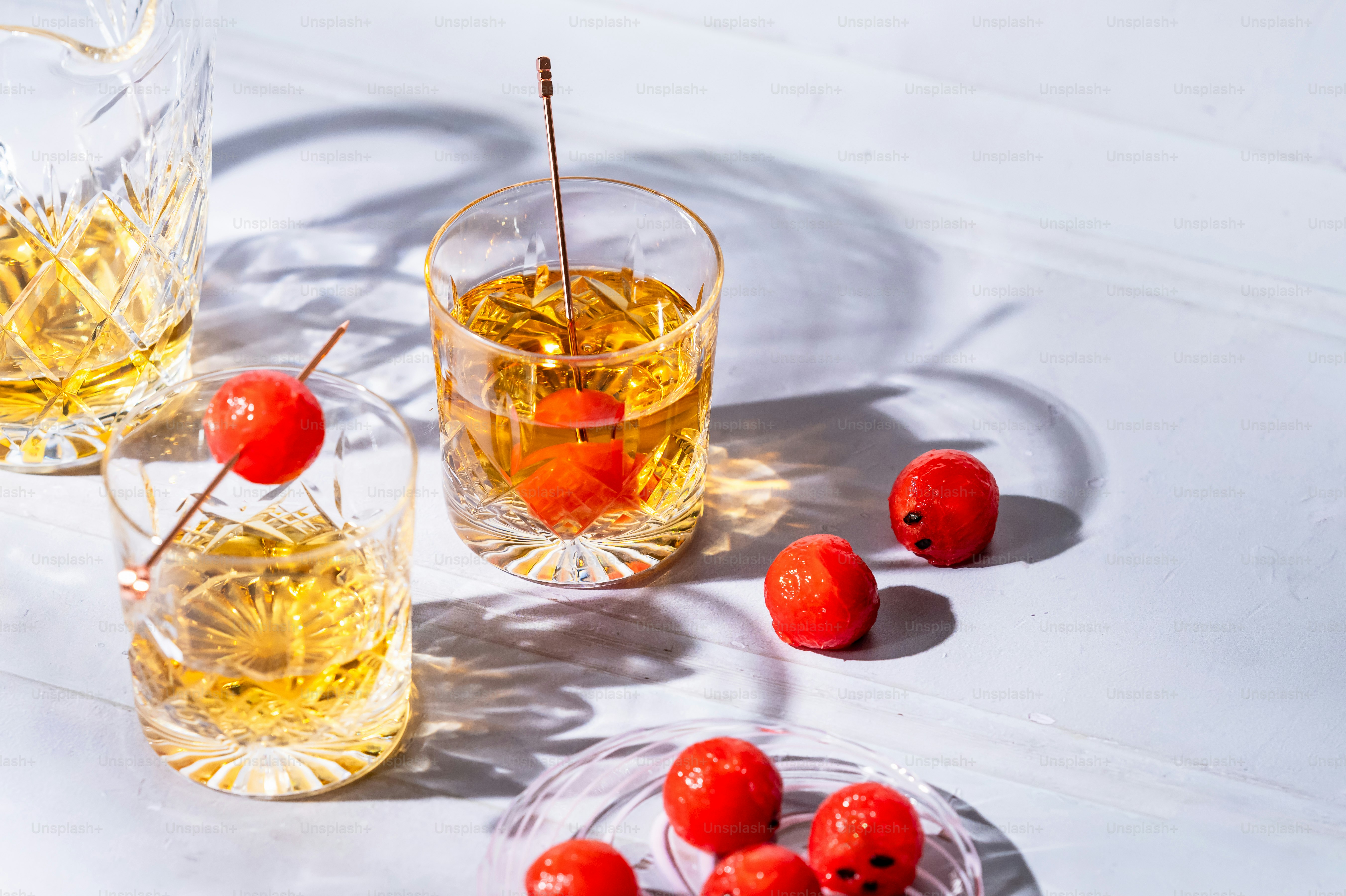A couple of glasses filled with liquid and cherries photo – Drinks ...
