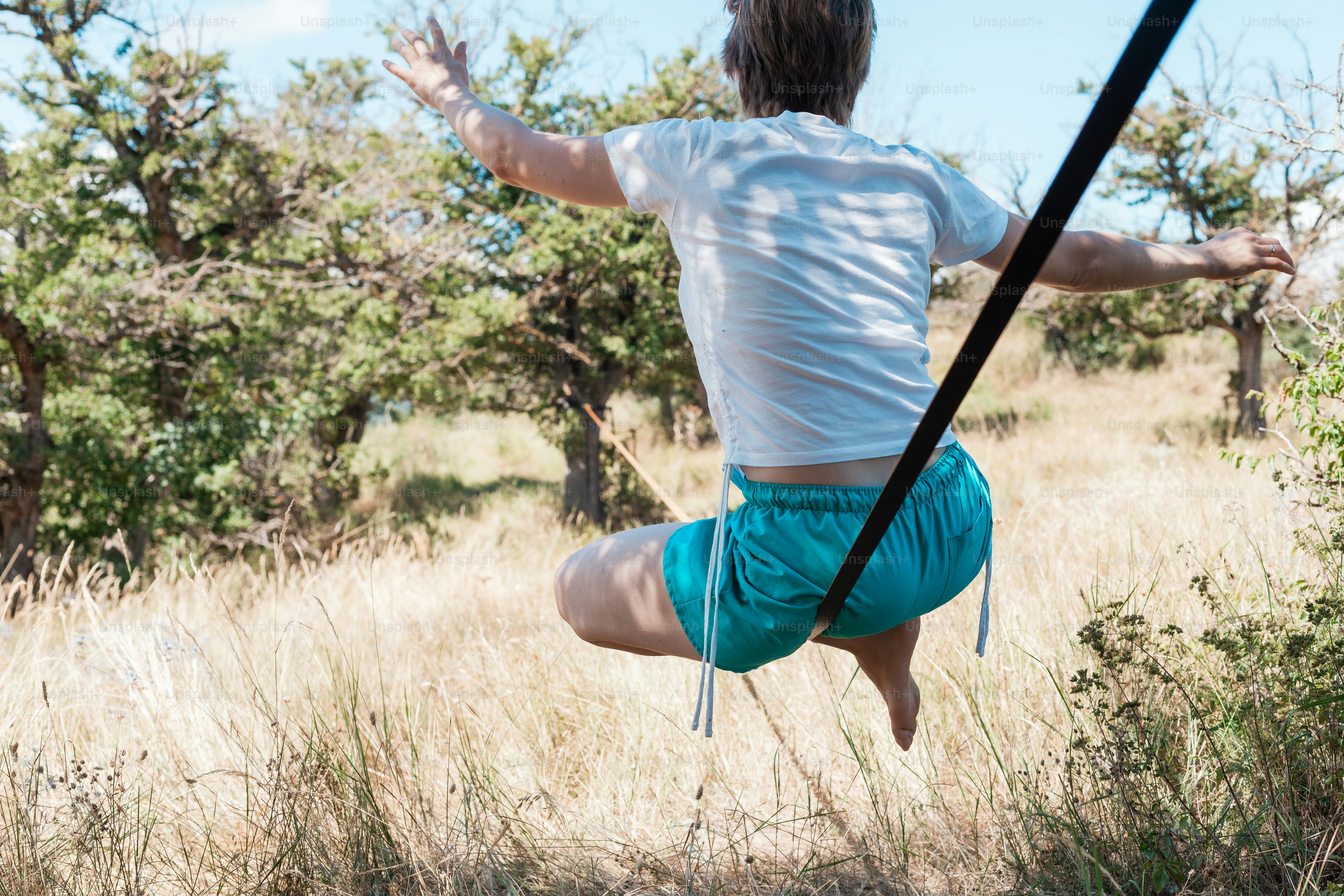 A person jumping in the air with a pole photo – Slackline Image on Unsplash