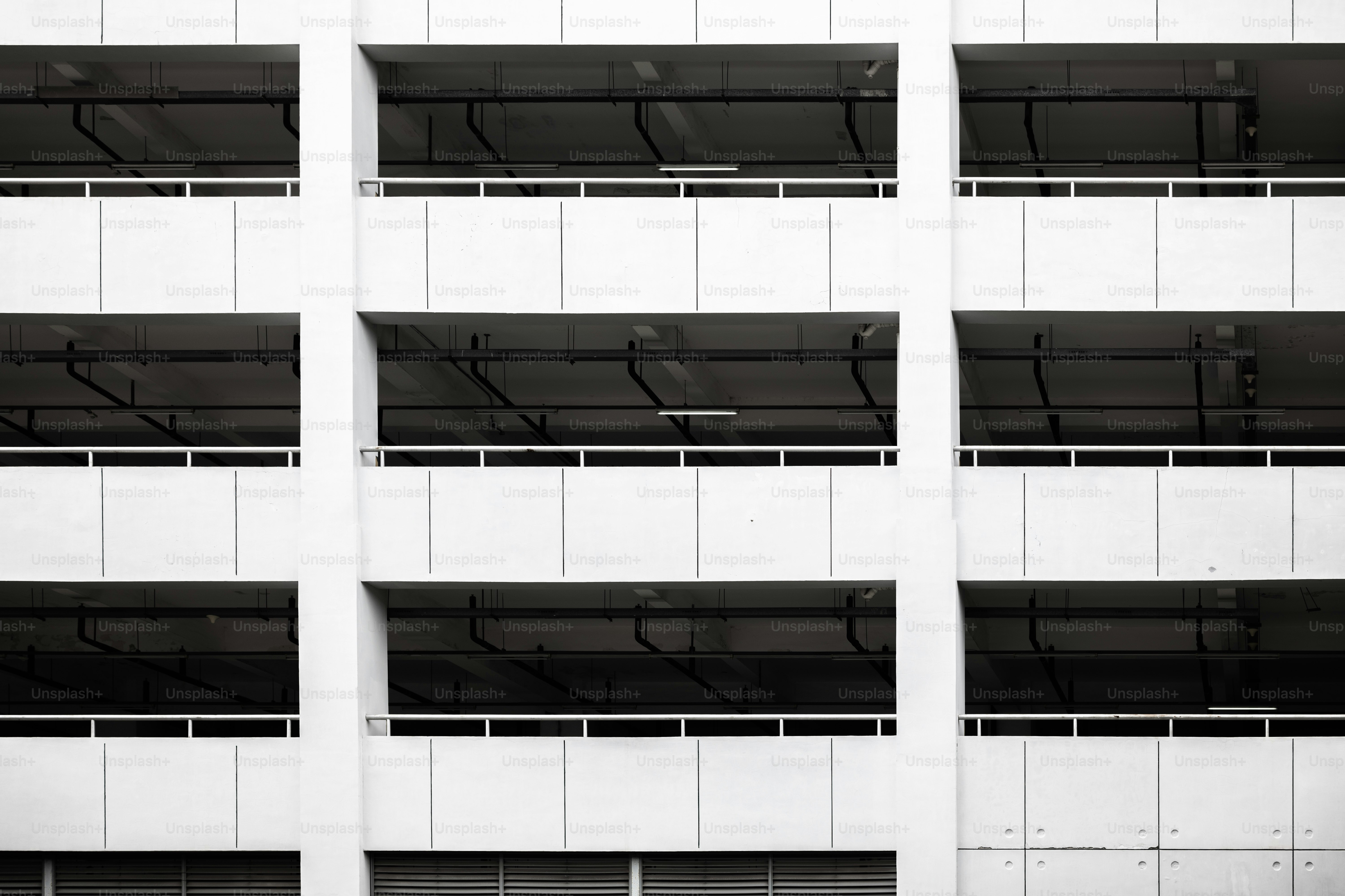 A tall white building with lots of windows photo – Parking lot Image on ...