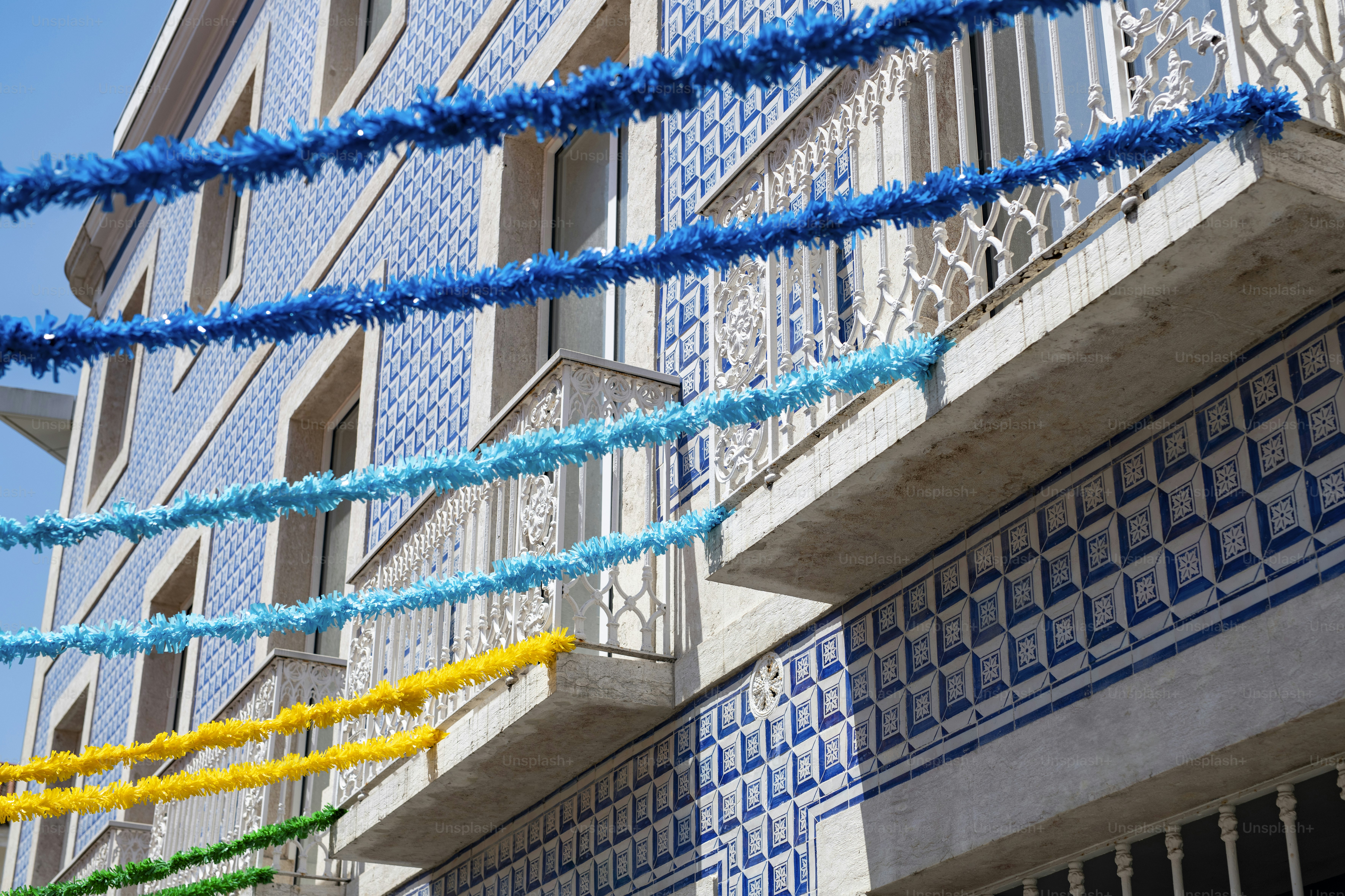 A bunch of colorful streamers hanging from a building photo ...