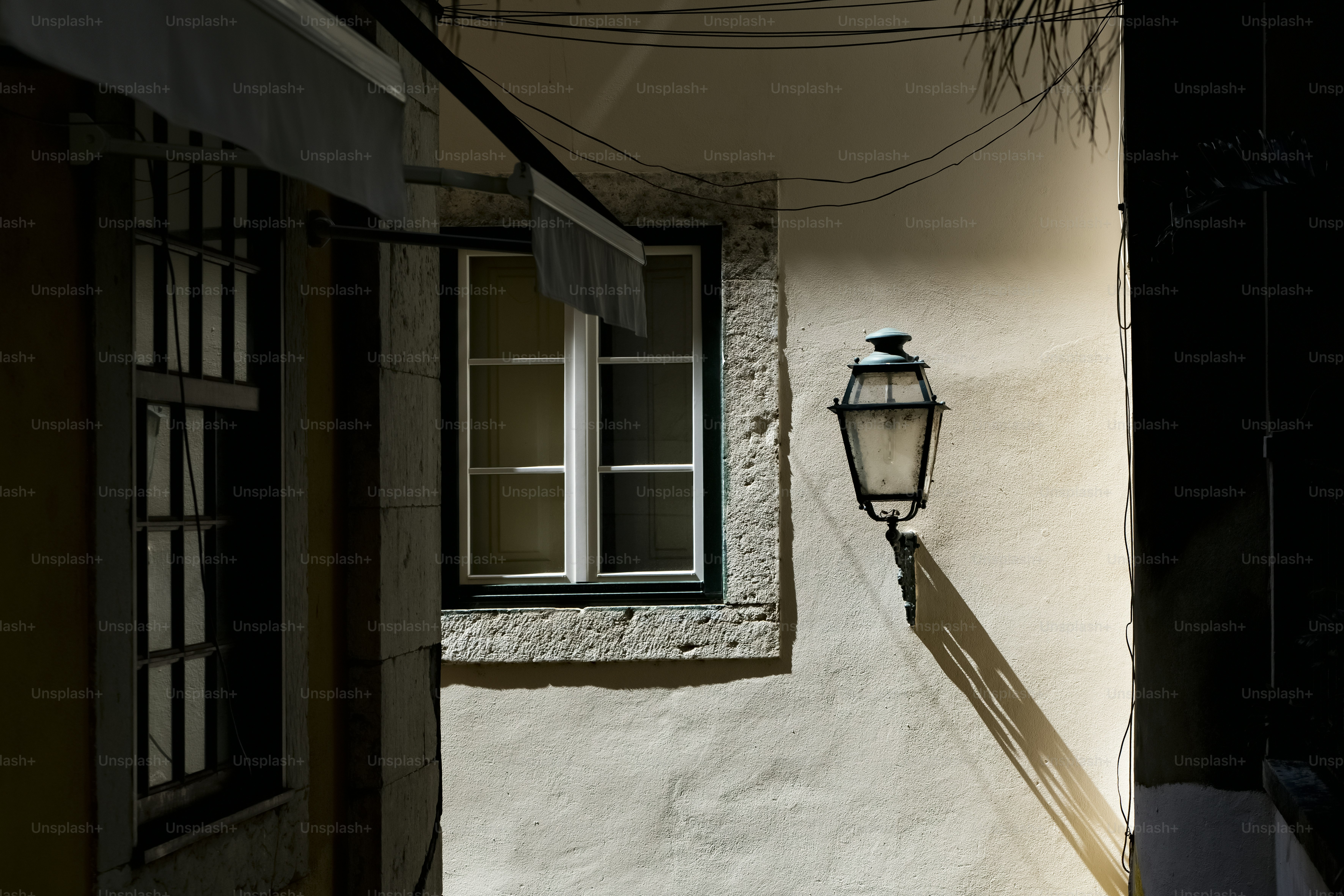 A lamp on the side of a building next to a window photo – Culture Image ...