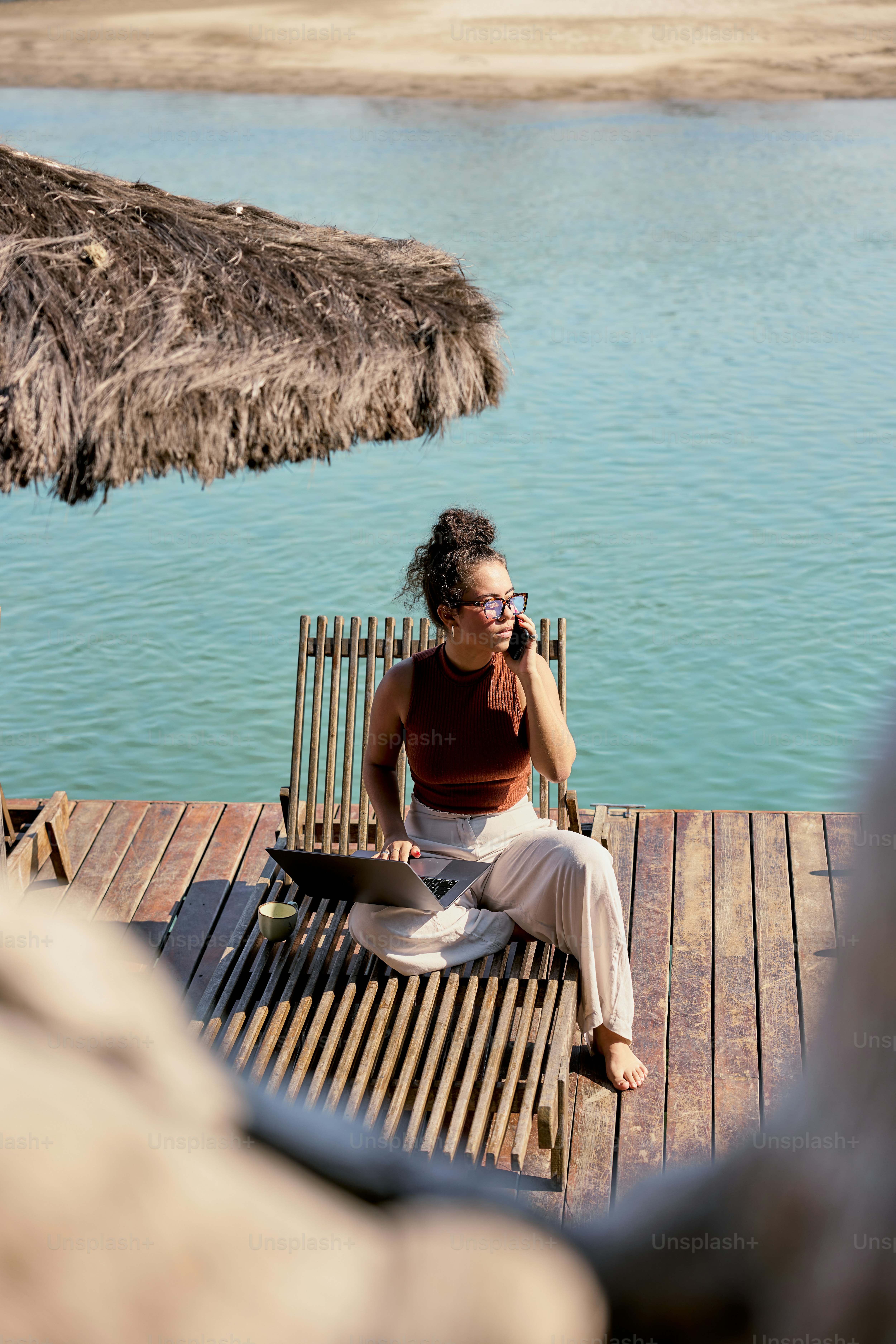 A woman sitting on a dock talking on a cell phone photo – Inspiration ...