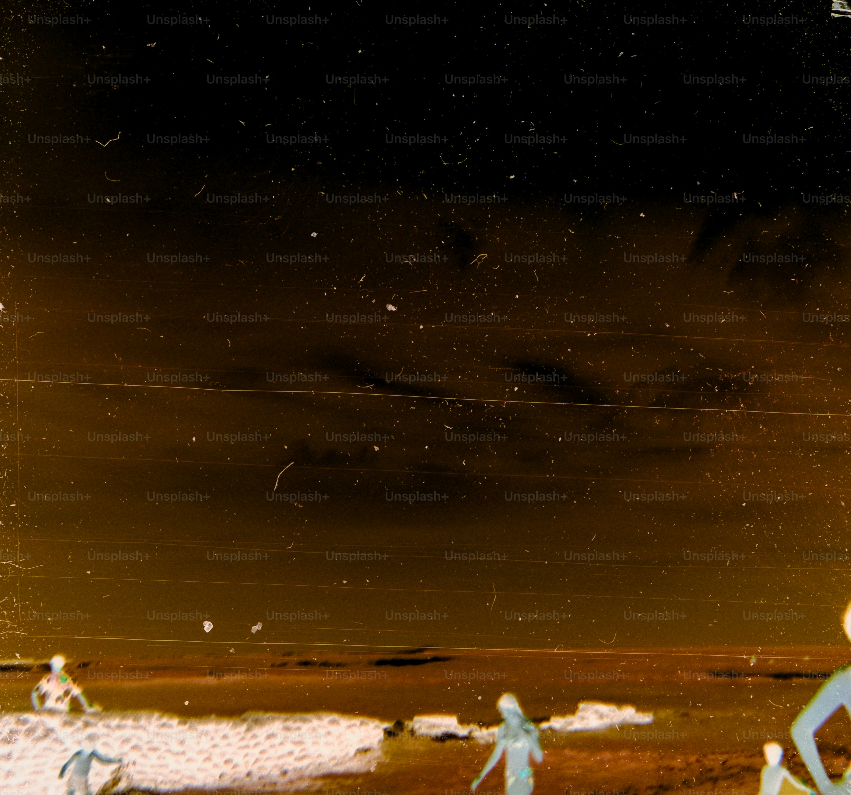 A group of people standing on top of a sandy beach photo – Negative ...