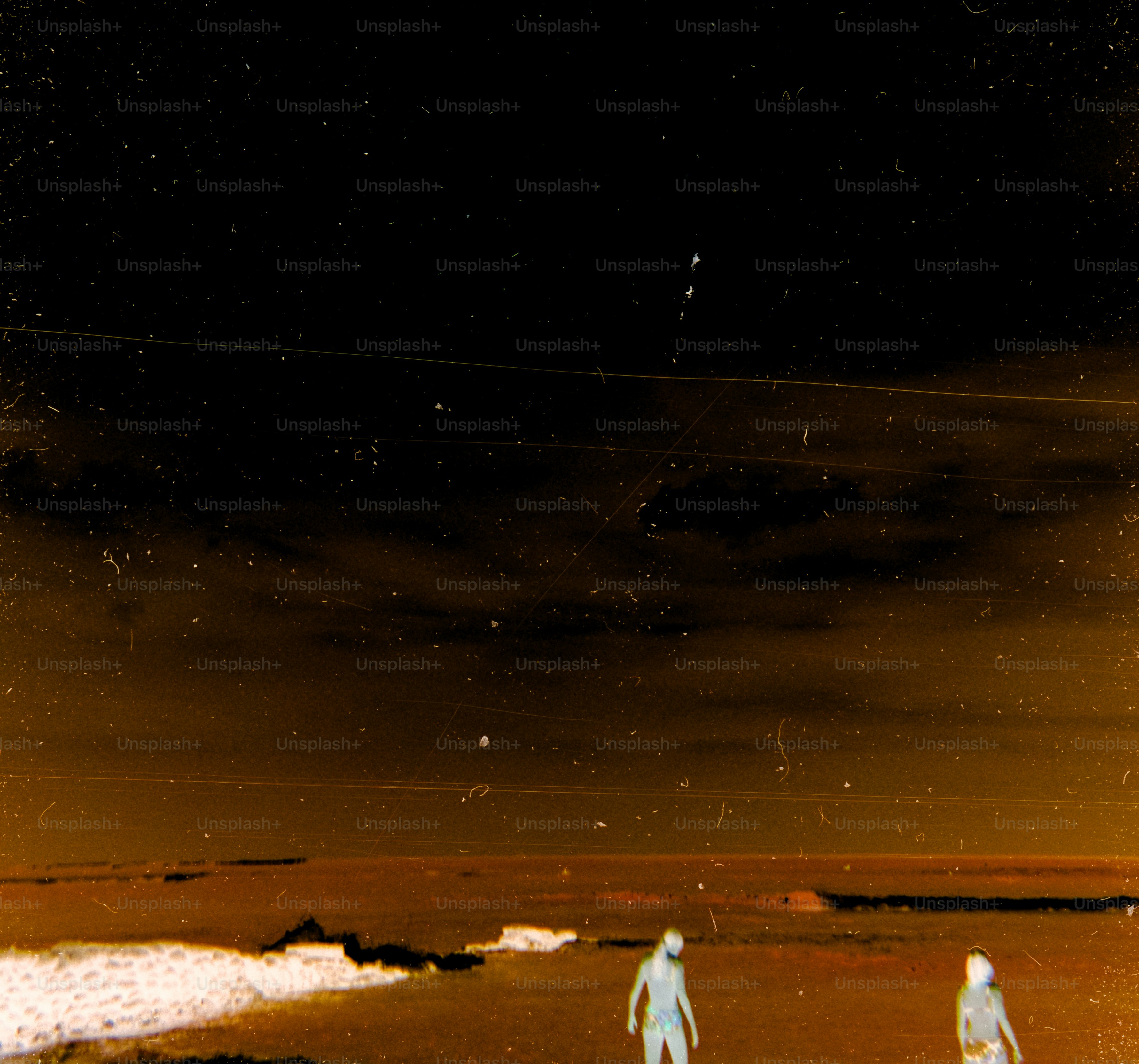 A group of people standing on top of a sandy beach photo – Negative ...