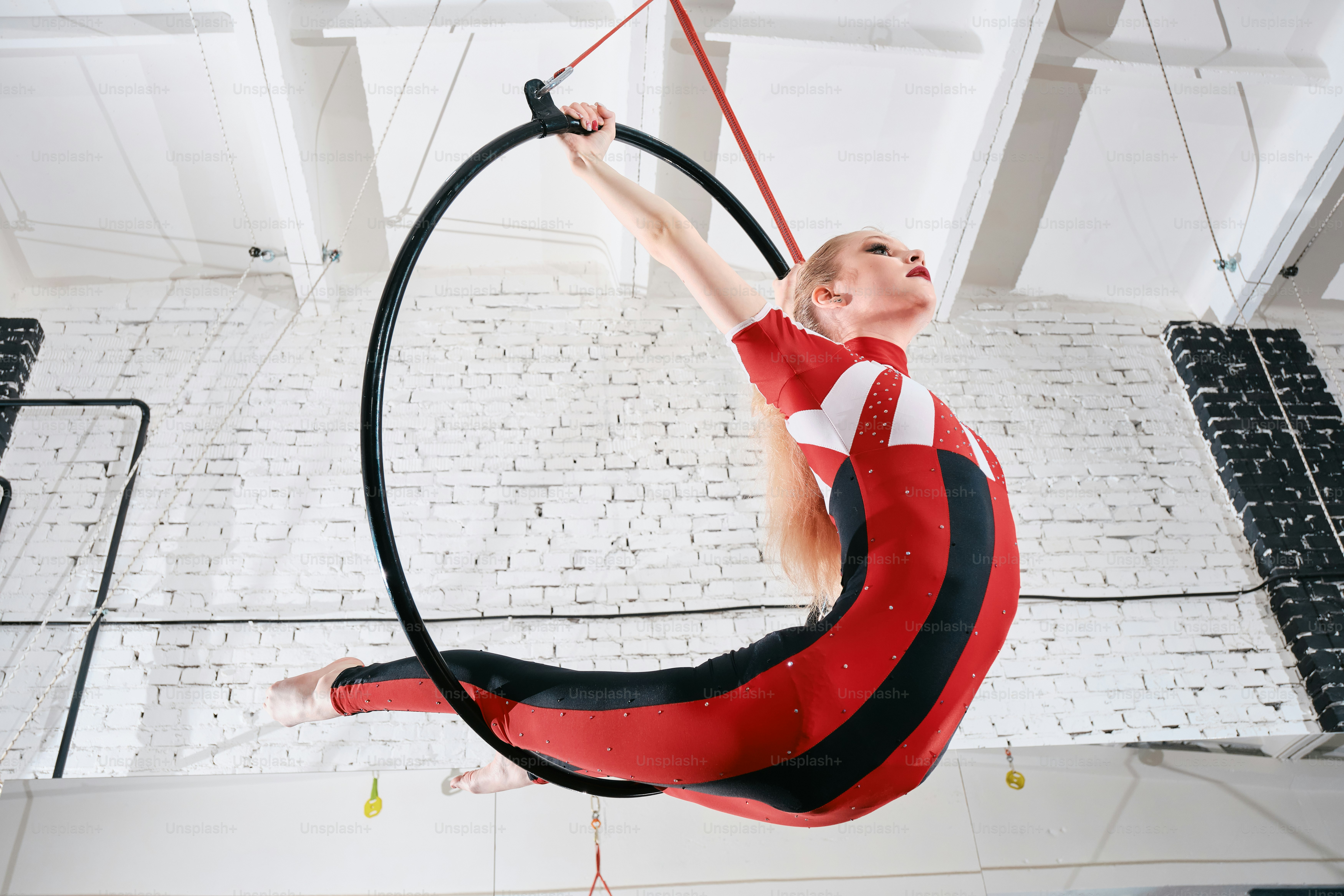 A woman in a red and black outfit doing aerial acrobatics photo ...
