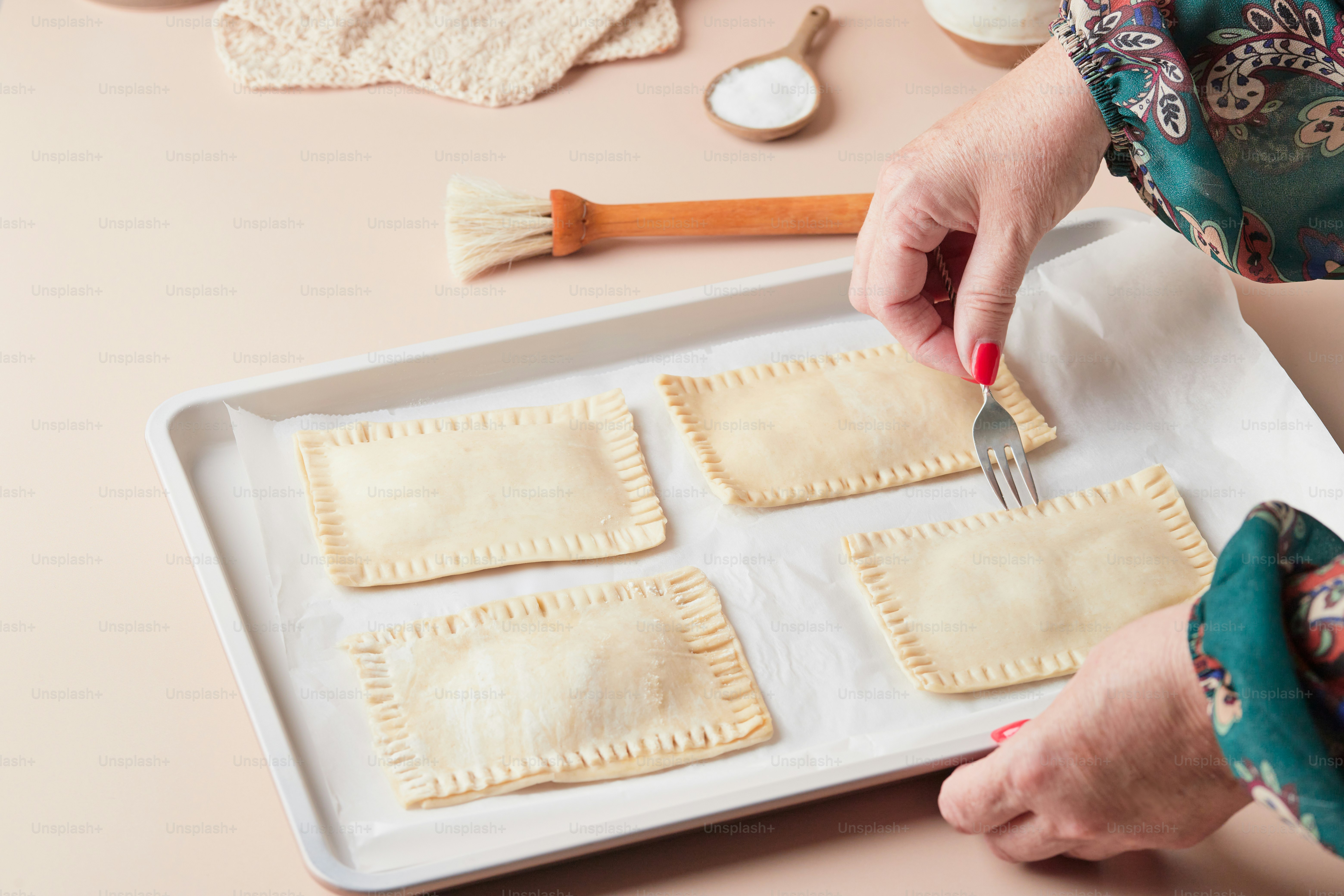 A woman is making homemade ravioli on a tray photo – Pie tart Image on ...