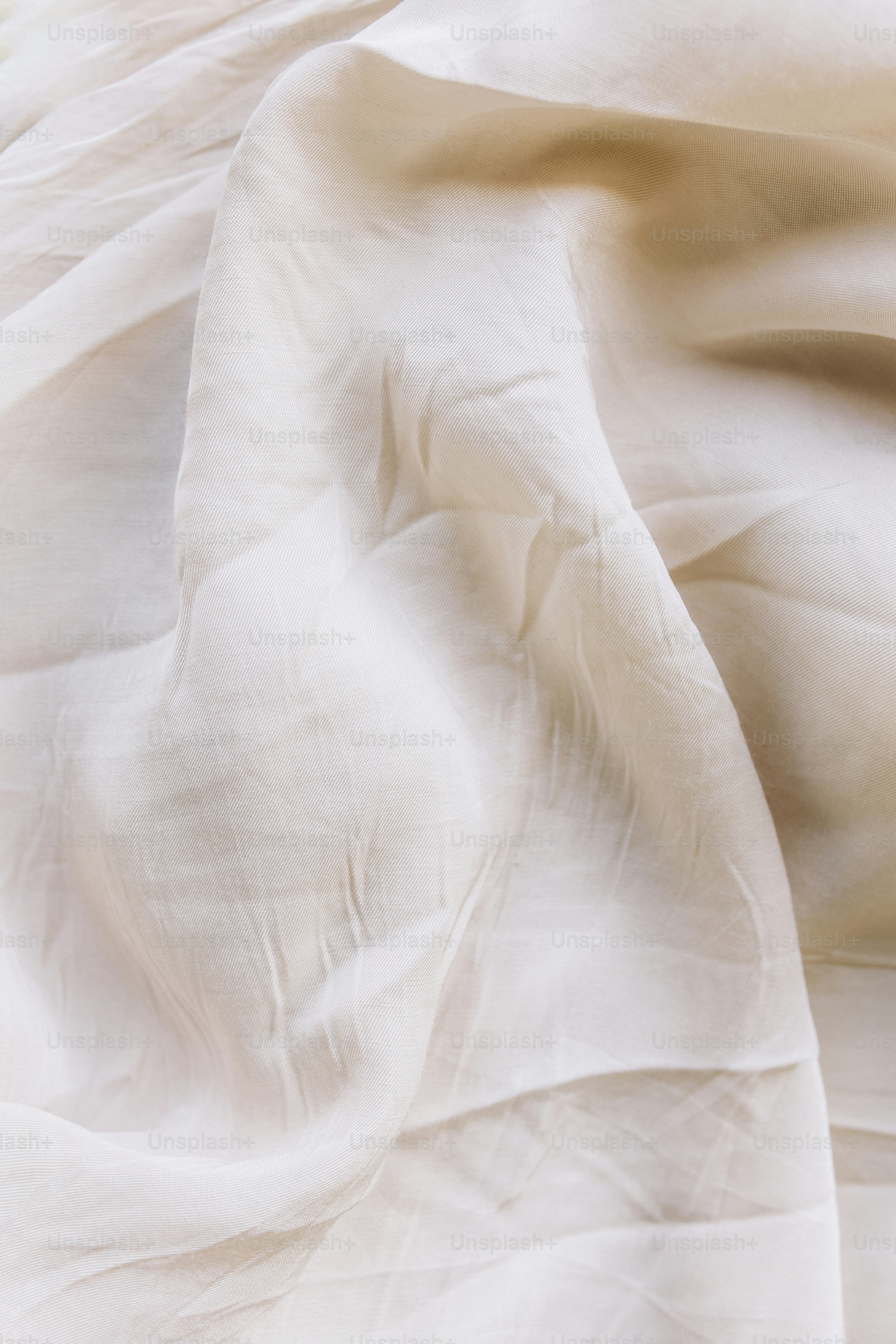 A close up of a bed with a white comforter photo – Neutral colors Image ...