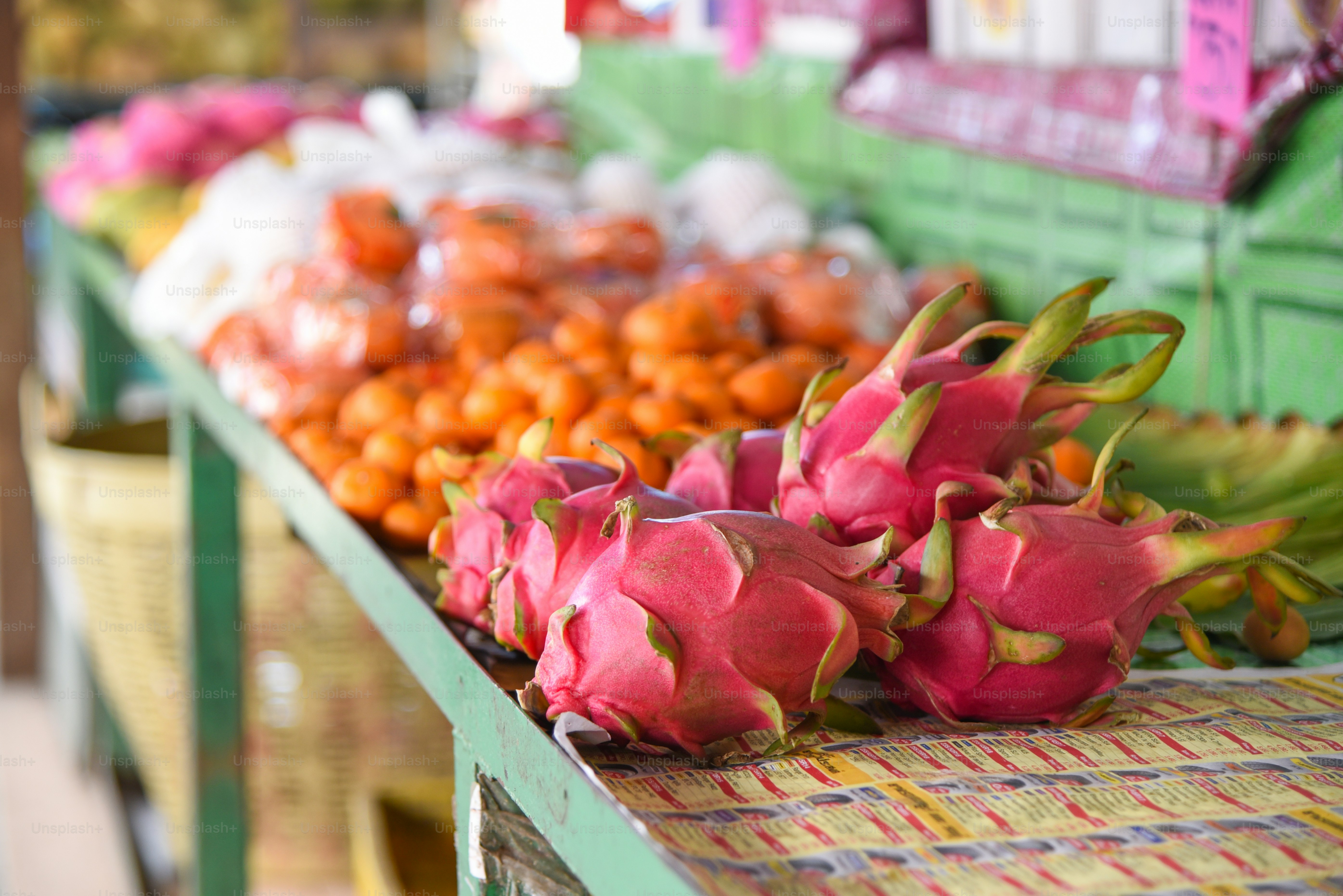Pineapples and dragon fruit are on display at a market photo – Thailand ...