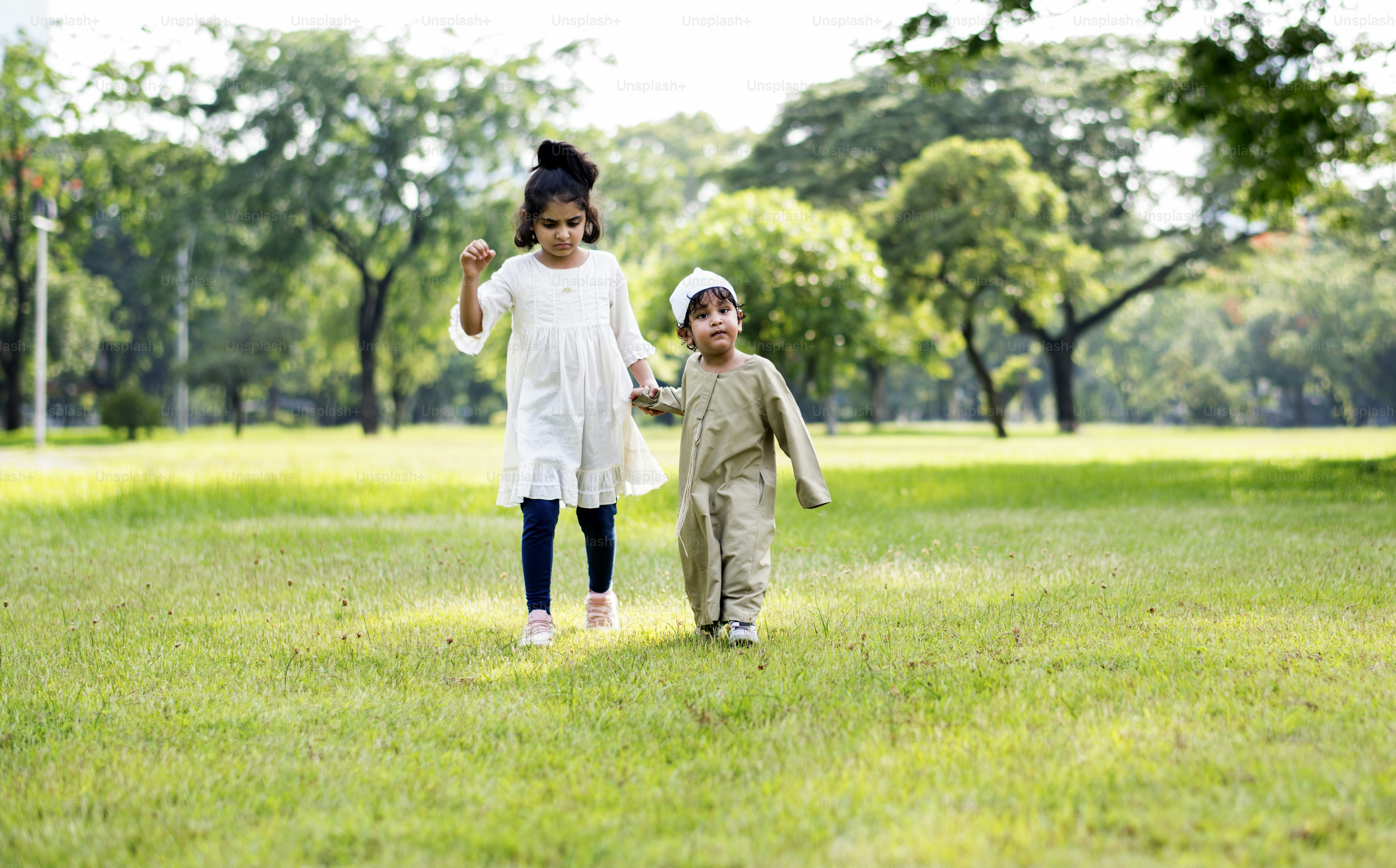 Muslim brother and sister playing in the park photo – Ramadan Image on ...