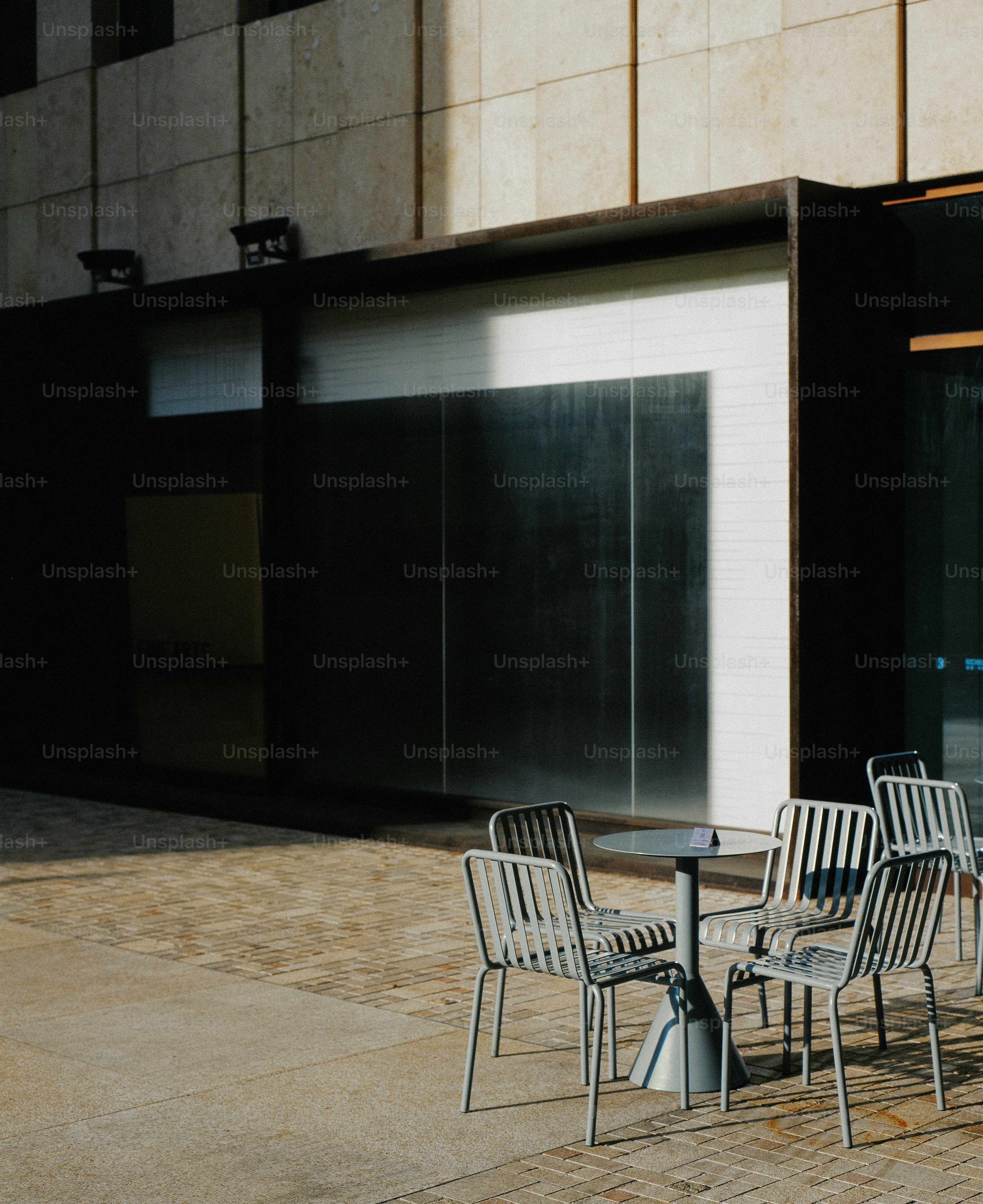A table and chairs outside of a building photo – Empty spaces Image on ...